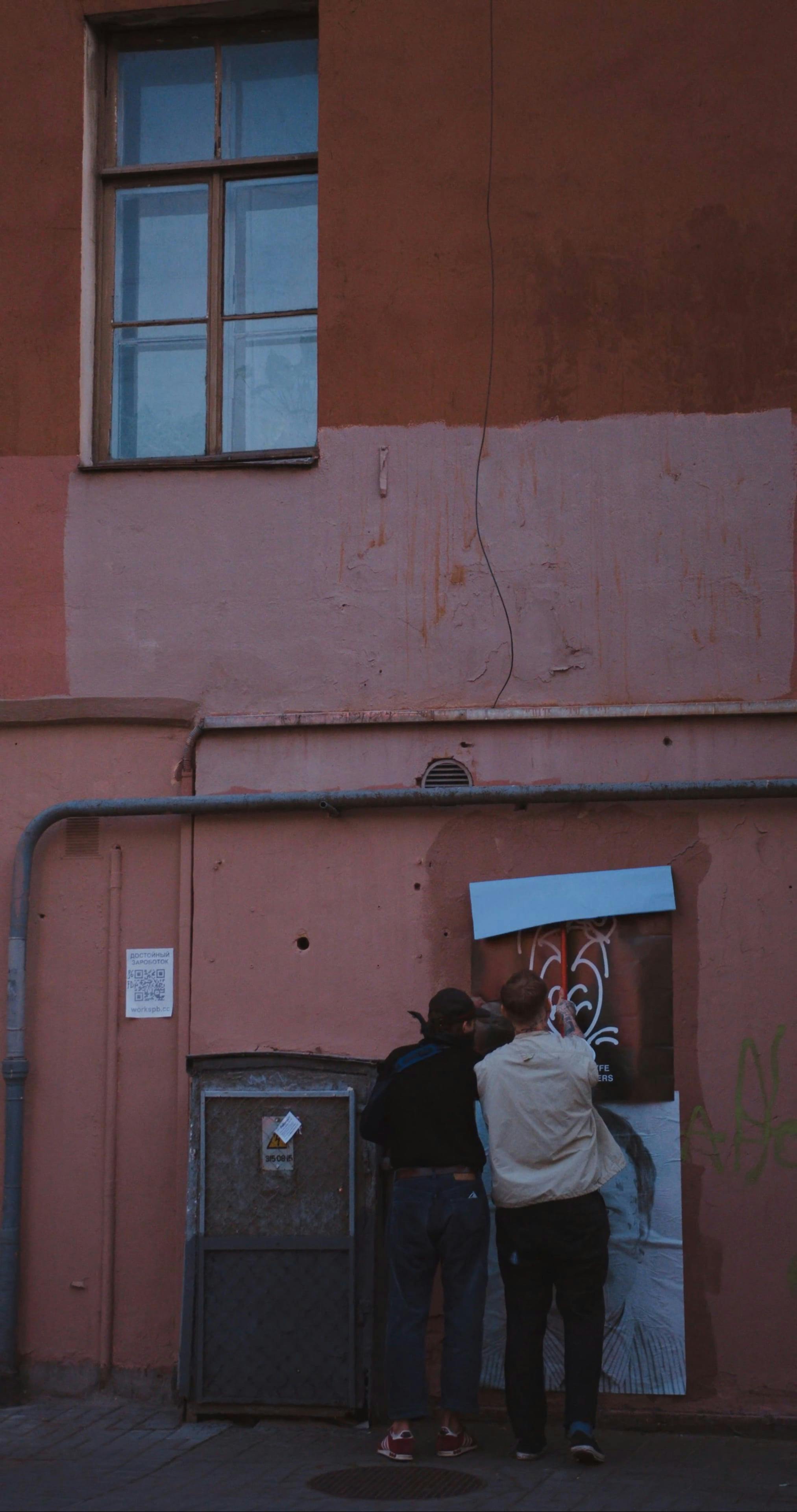 People Sticking Poster on the Wall · Free Stock Video