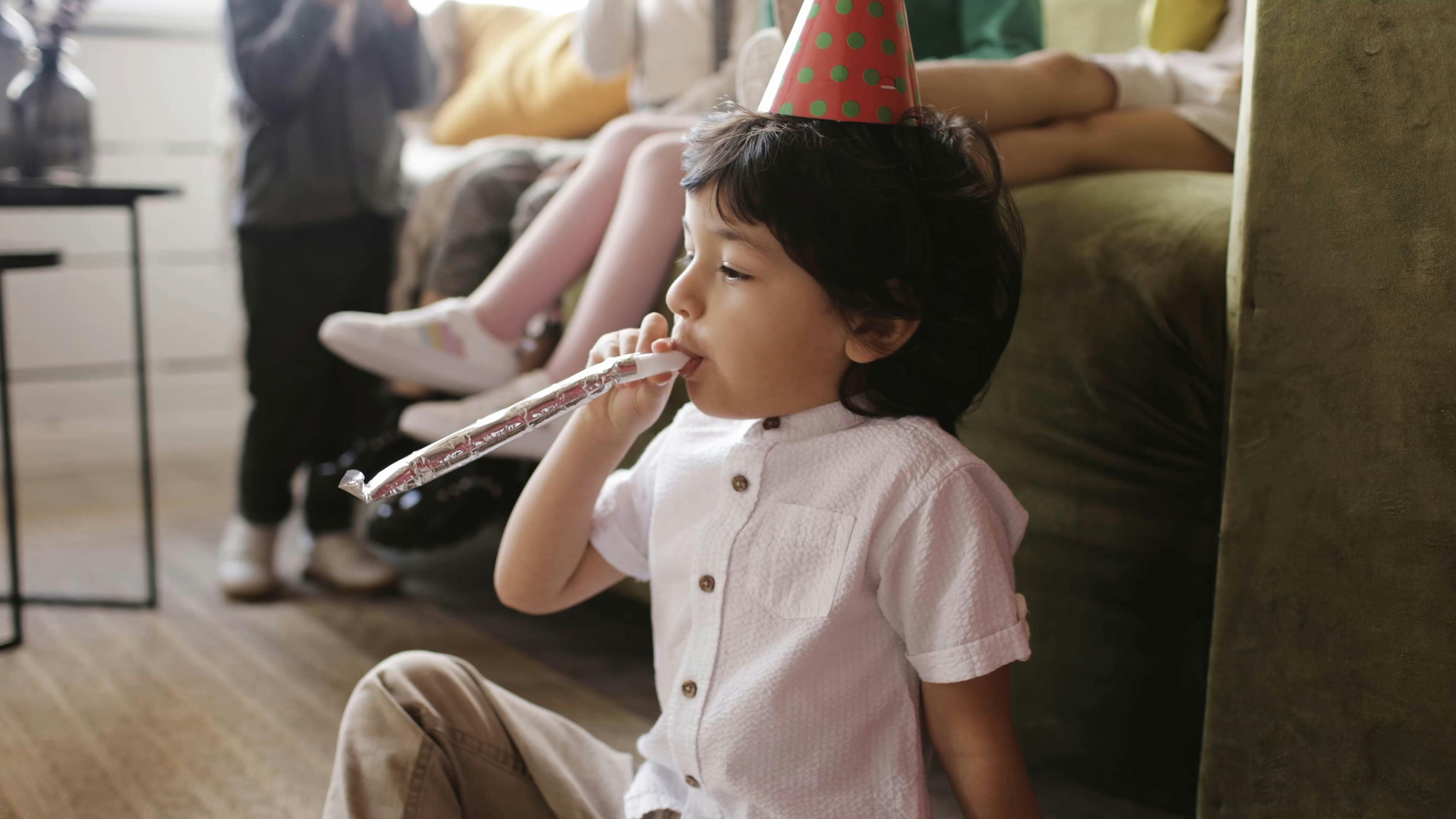 Children Wearing Party Hats and Using a Party Horn Hiding Under the ...