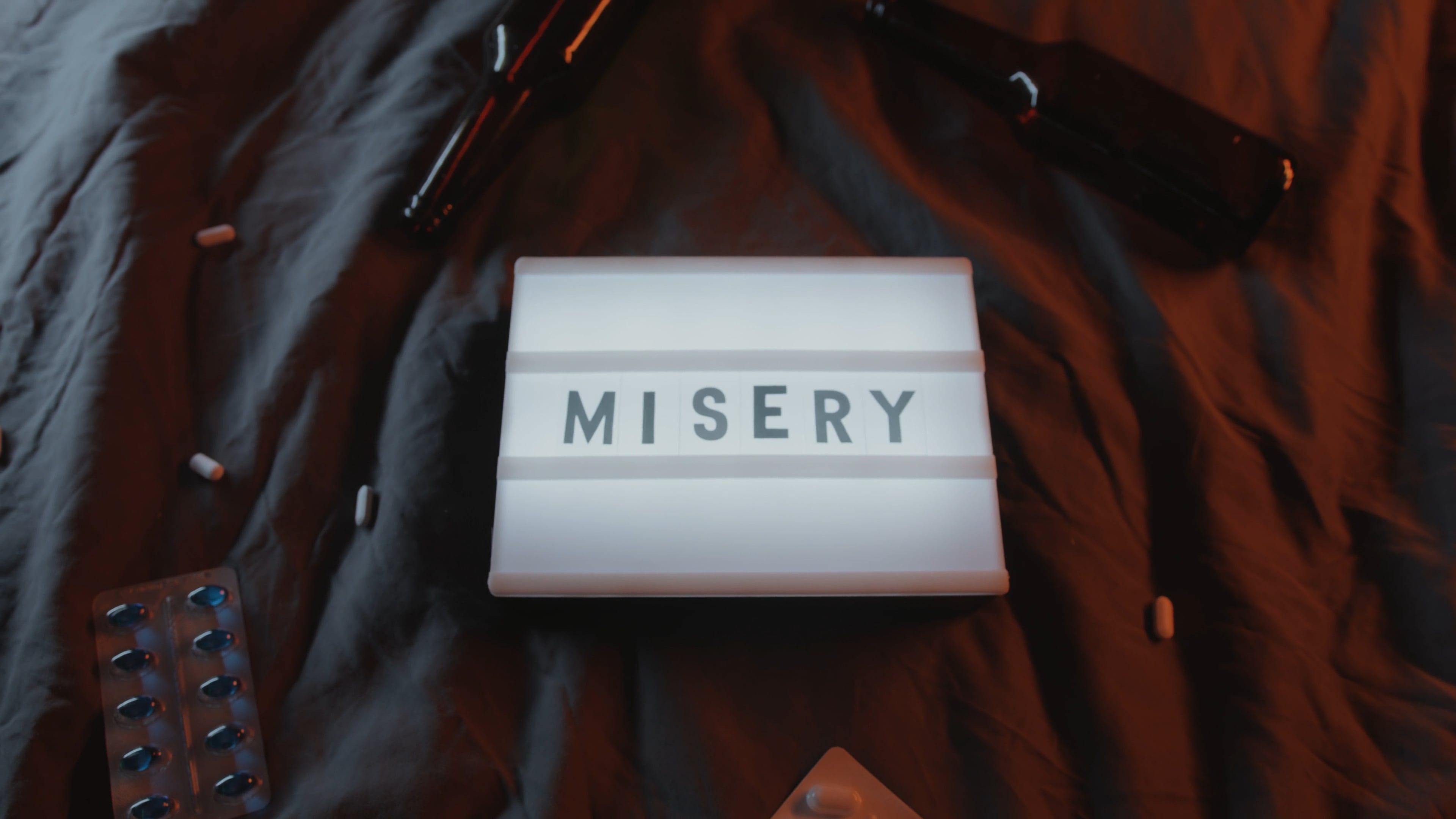 Misery Signage on the Bed with Pills and Bottle · Free Stock Video