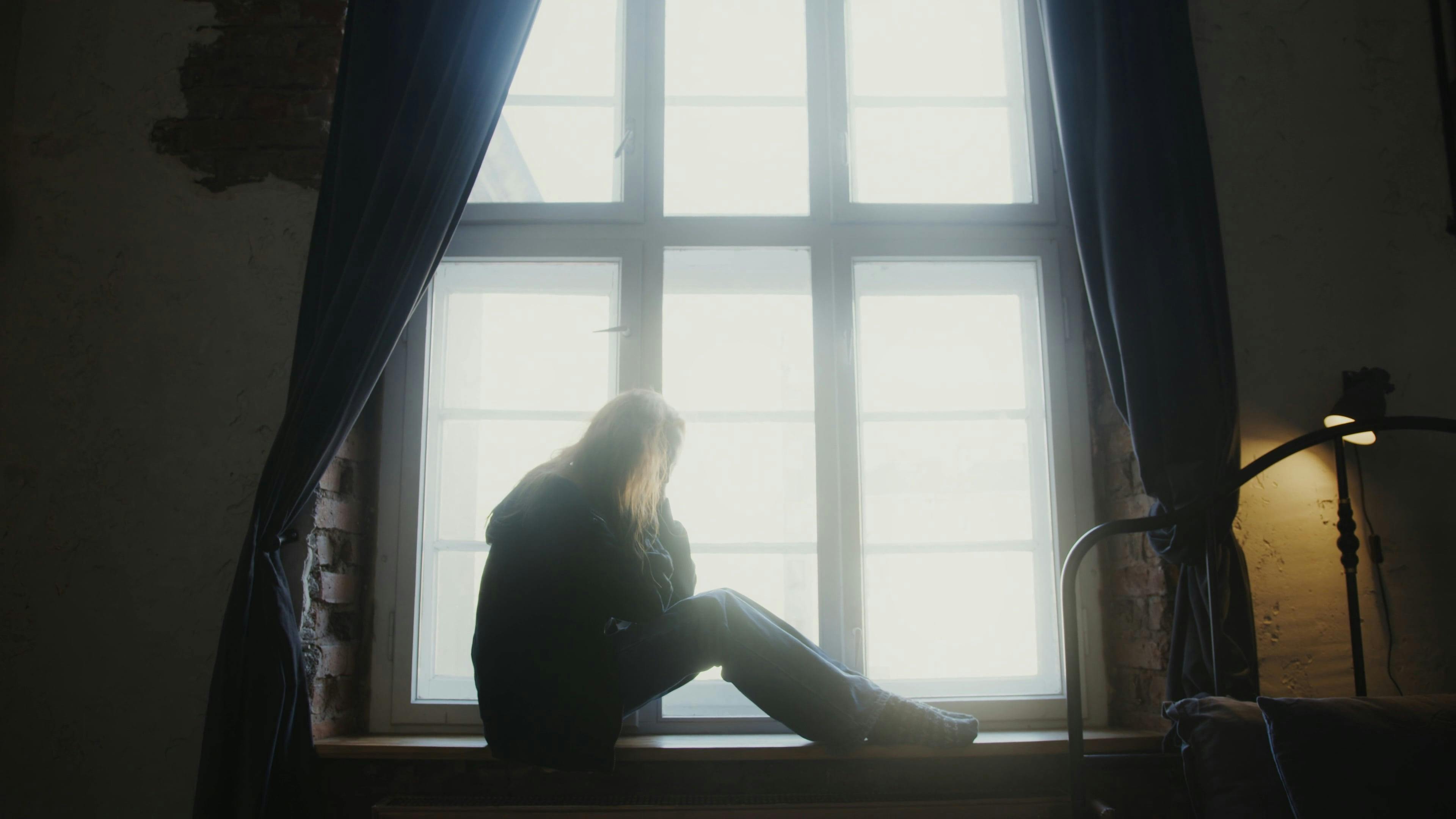 Emotional Woman Sitting on the Window · Free Stock Video