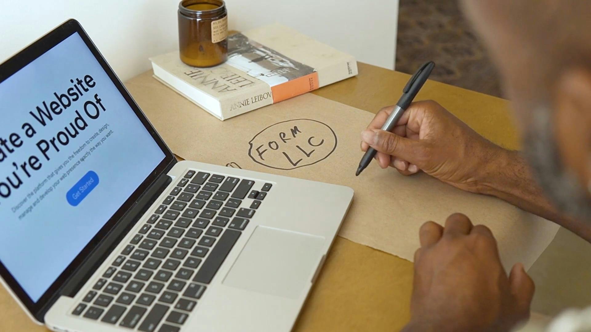 A Man Writing on a Paper in Front of His Laptop · Free Stock Video