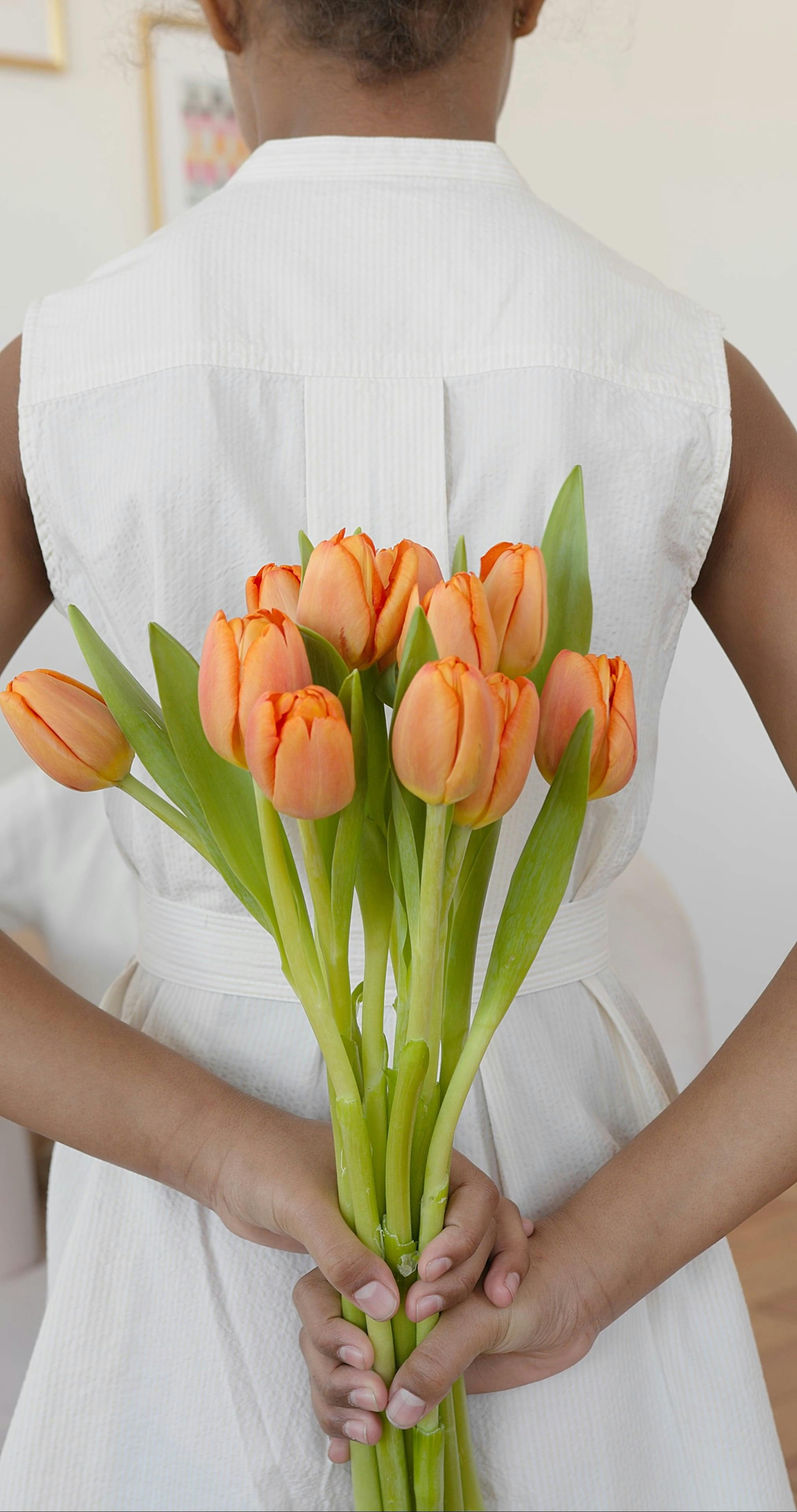 A Woman Holding Flowers Behind her Back · Free Stock Video