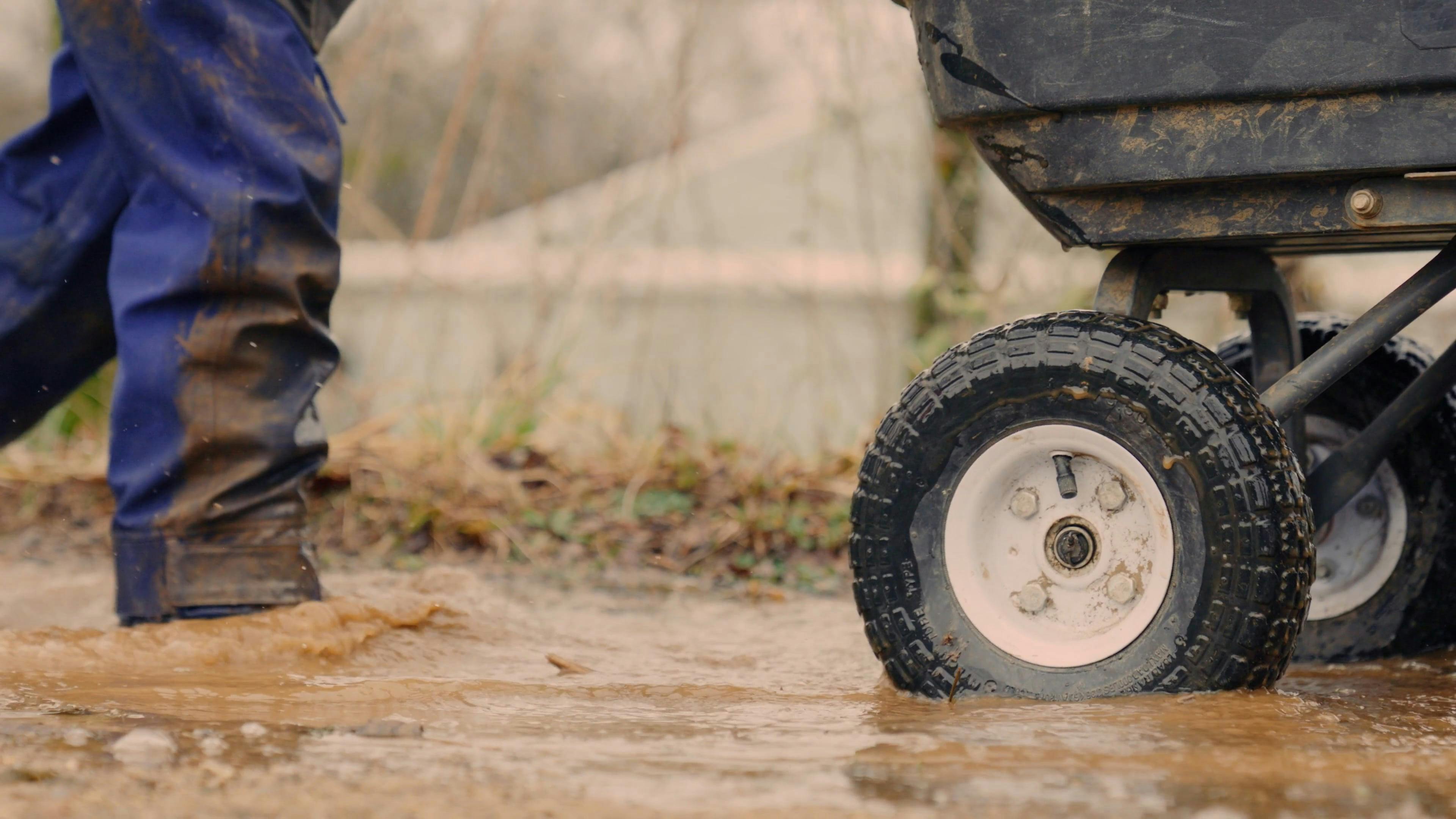 A Person Pushing a Cart on a Muddy Puddle Free Stock Video Footage ...