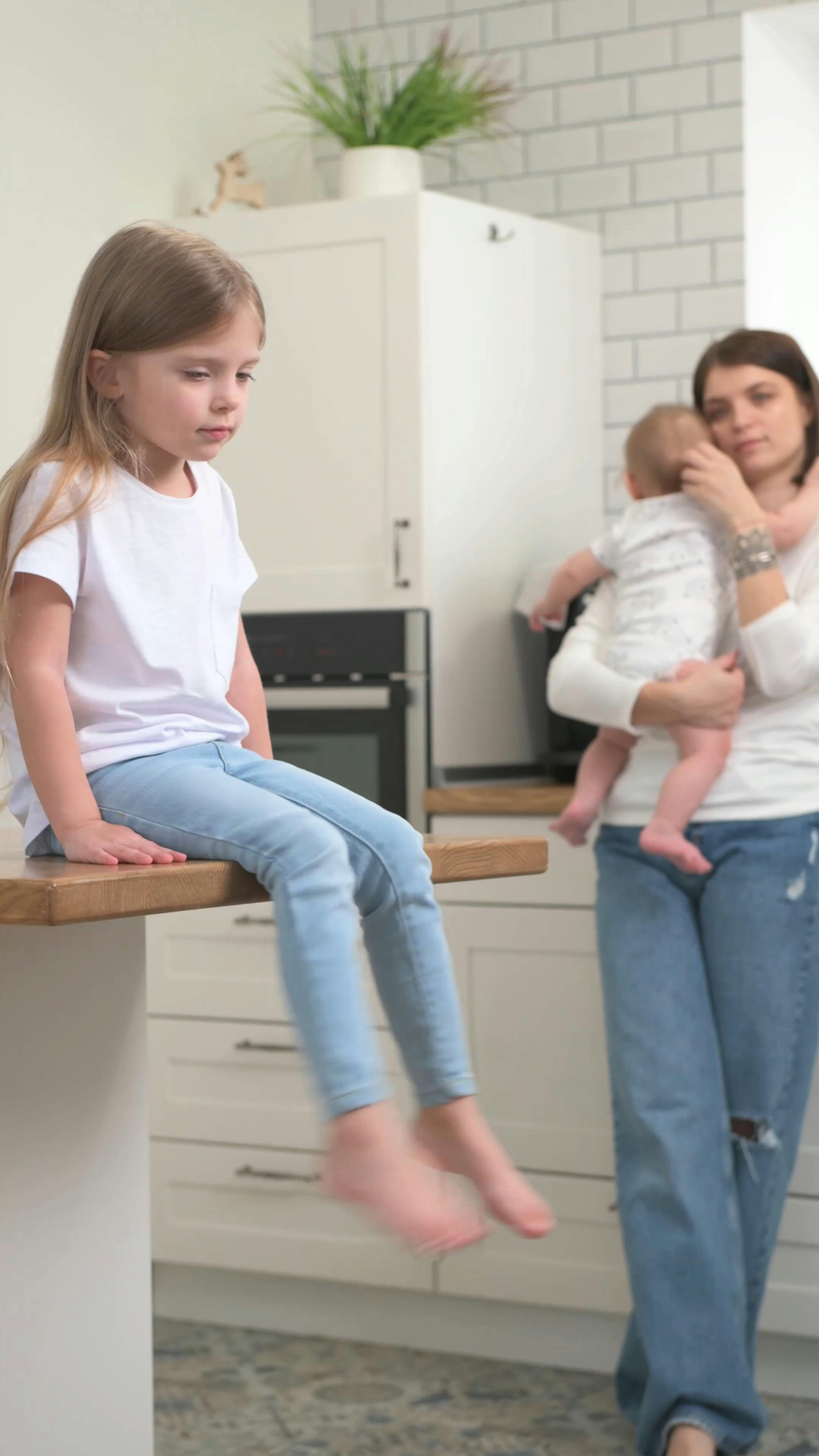 Mother Taking Care Of a Baby and A Girl Swaying Her Feet · Free Stock Video