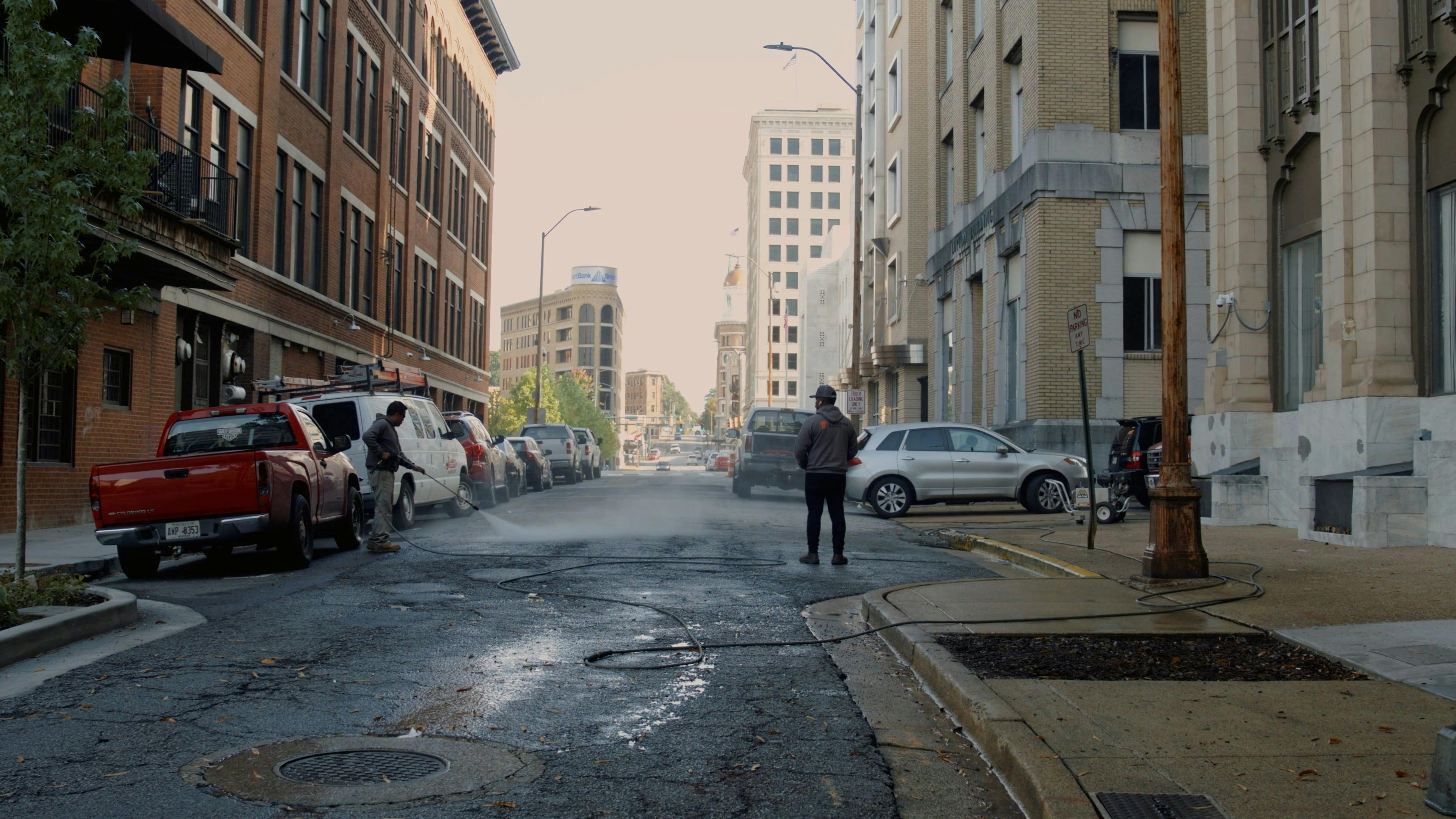 A Man Cleaning the Road Using Pressured Water Hose Free Stock Video ...