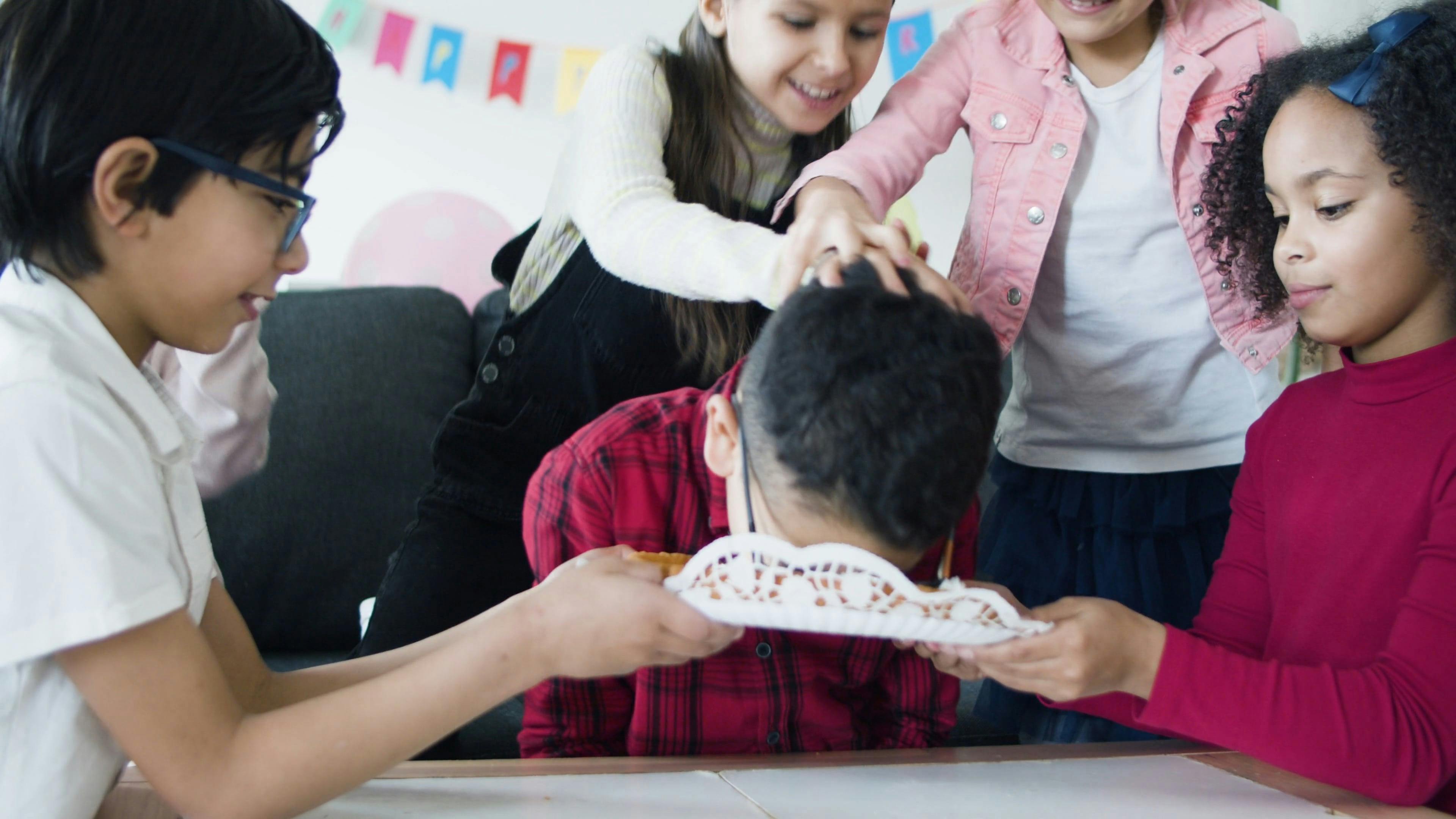 Kids Playing while Putting the Boy Face into the Icing Cake Free Stock ...