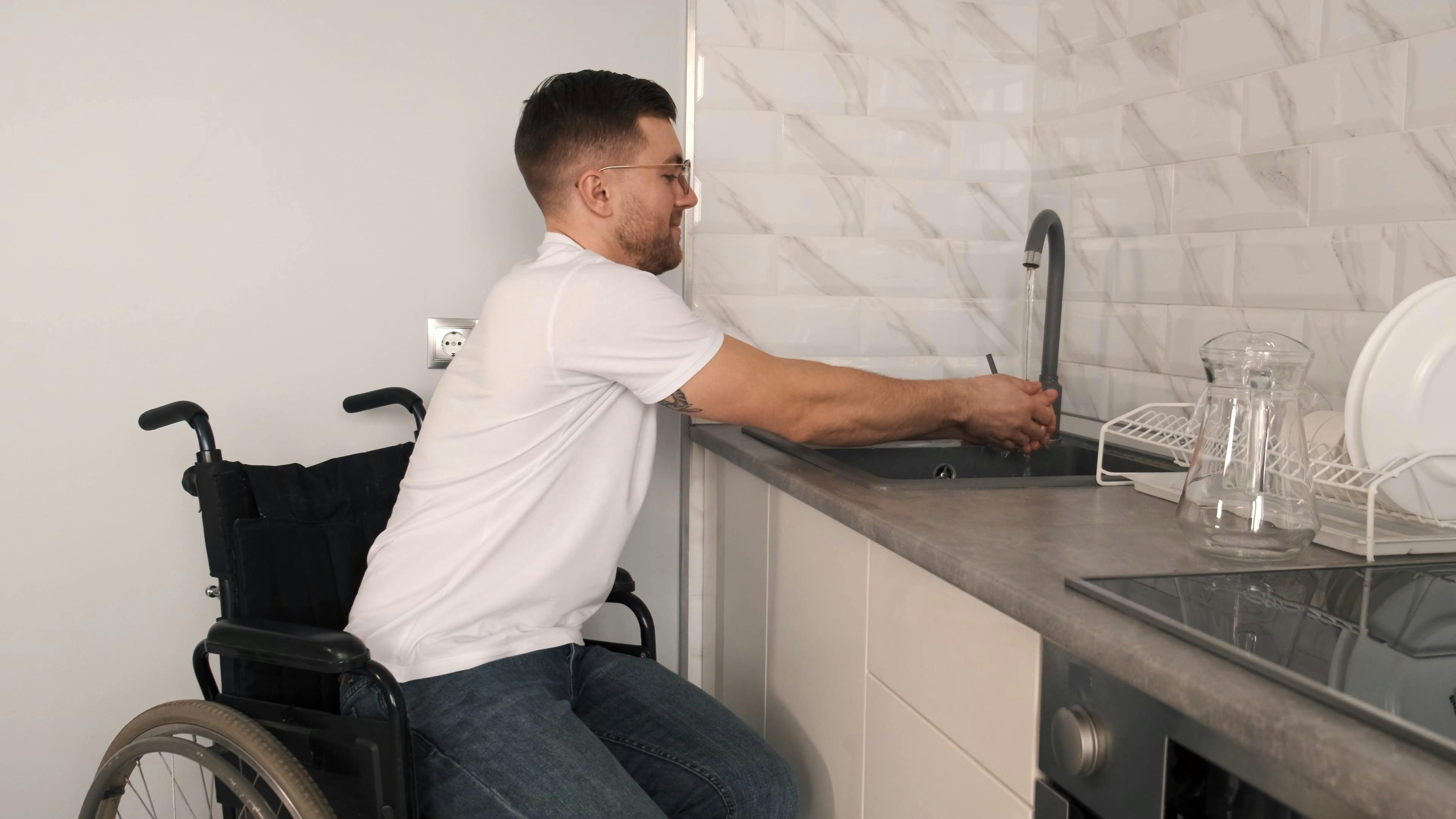 Man on a Wheelchair Washing his Hands before Slicing the Tomatoes ...
