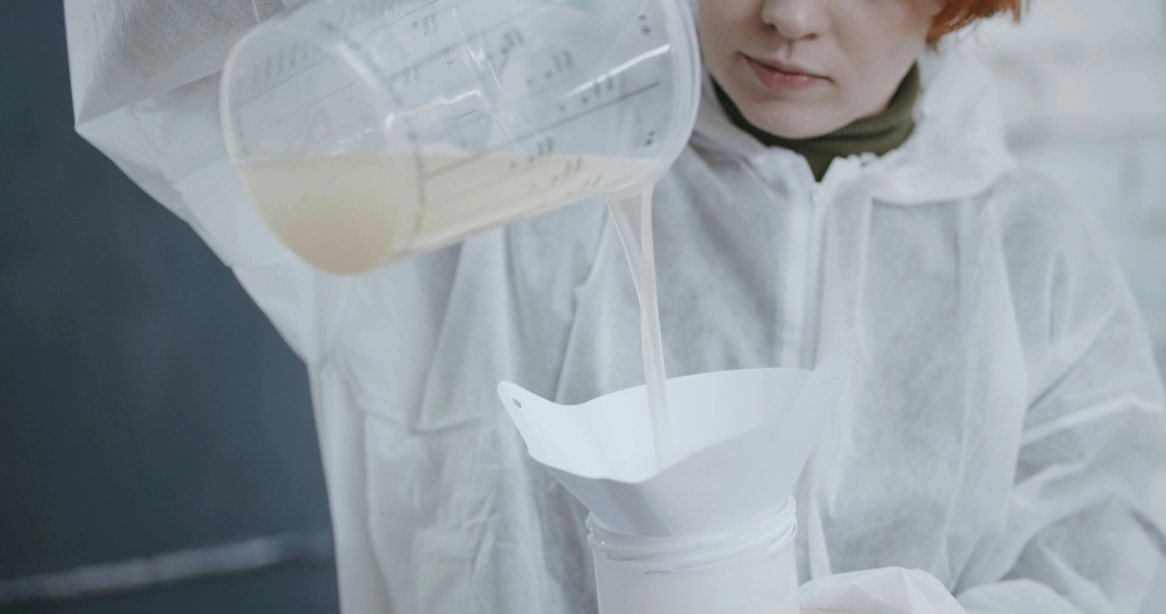 A Woman Transferring Liquid to a Plastic Container Free Stock Video ...