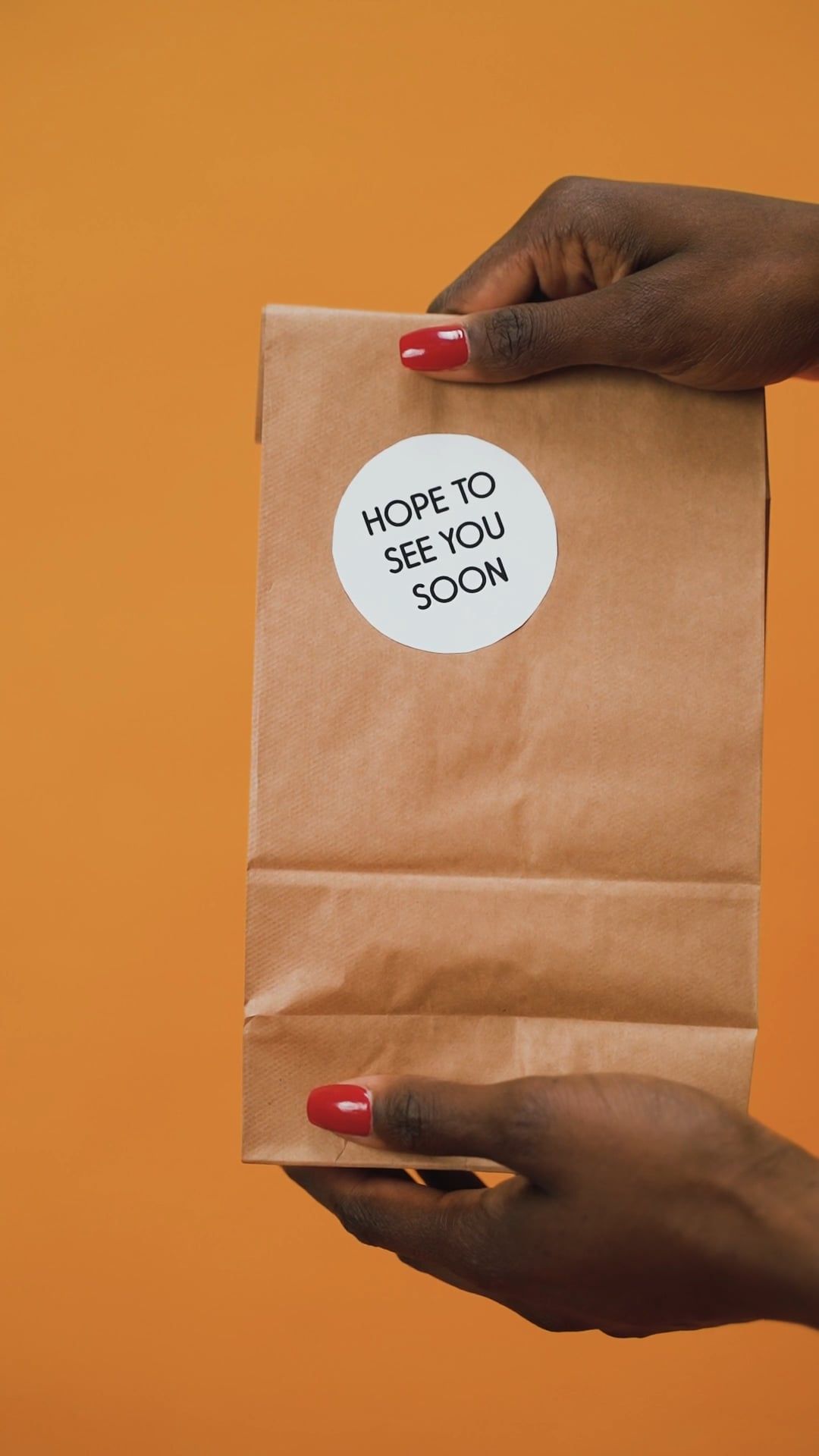Person Holding a Paper Bag with Sticker Message · Free Stock Video