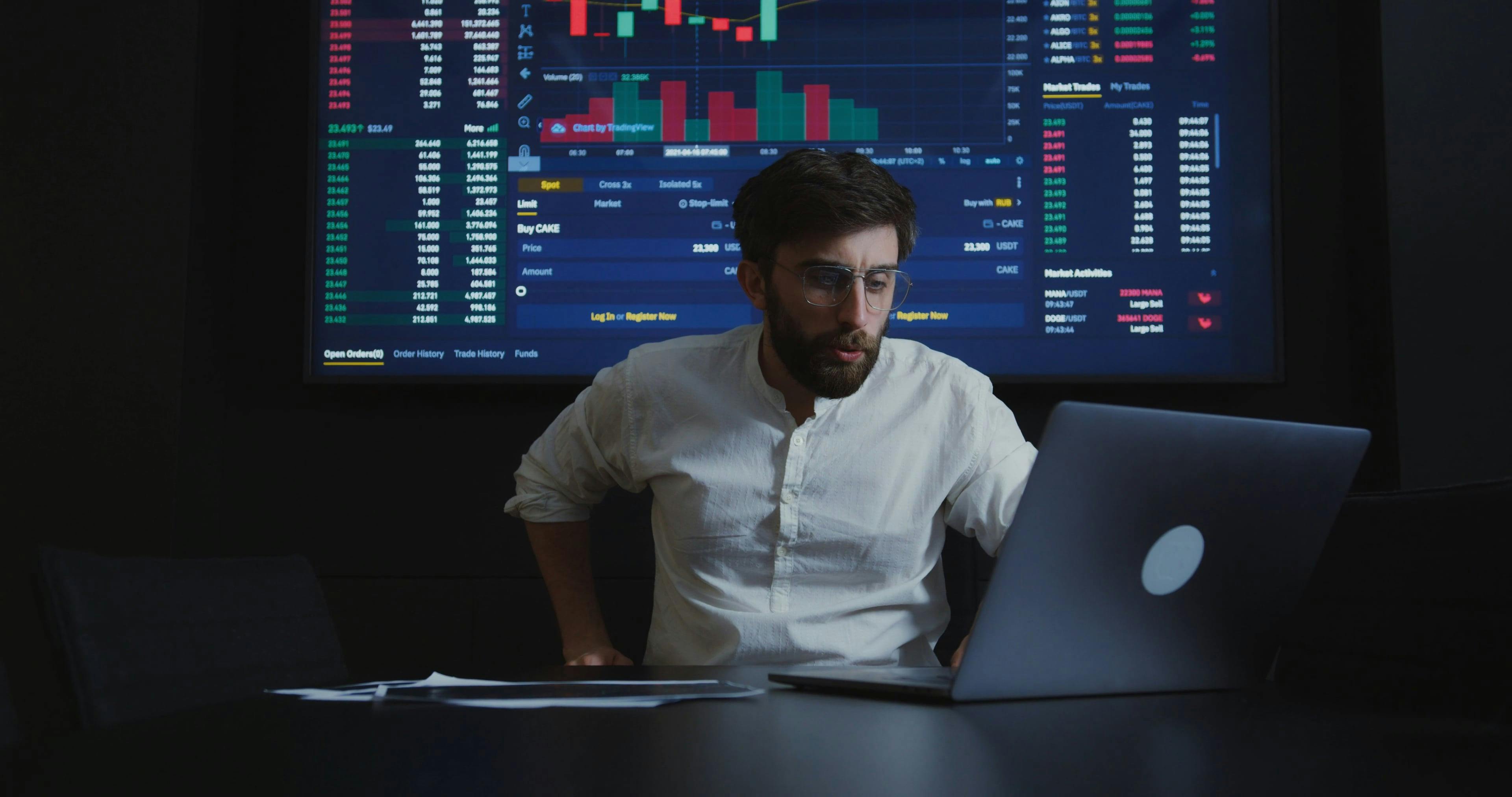 Man In Front of a Big Screen Using his Laptop · Free Stock Video