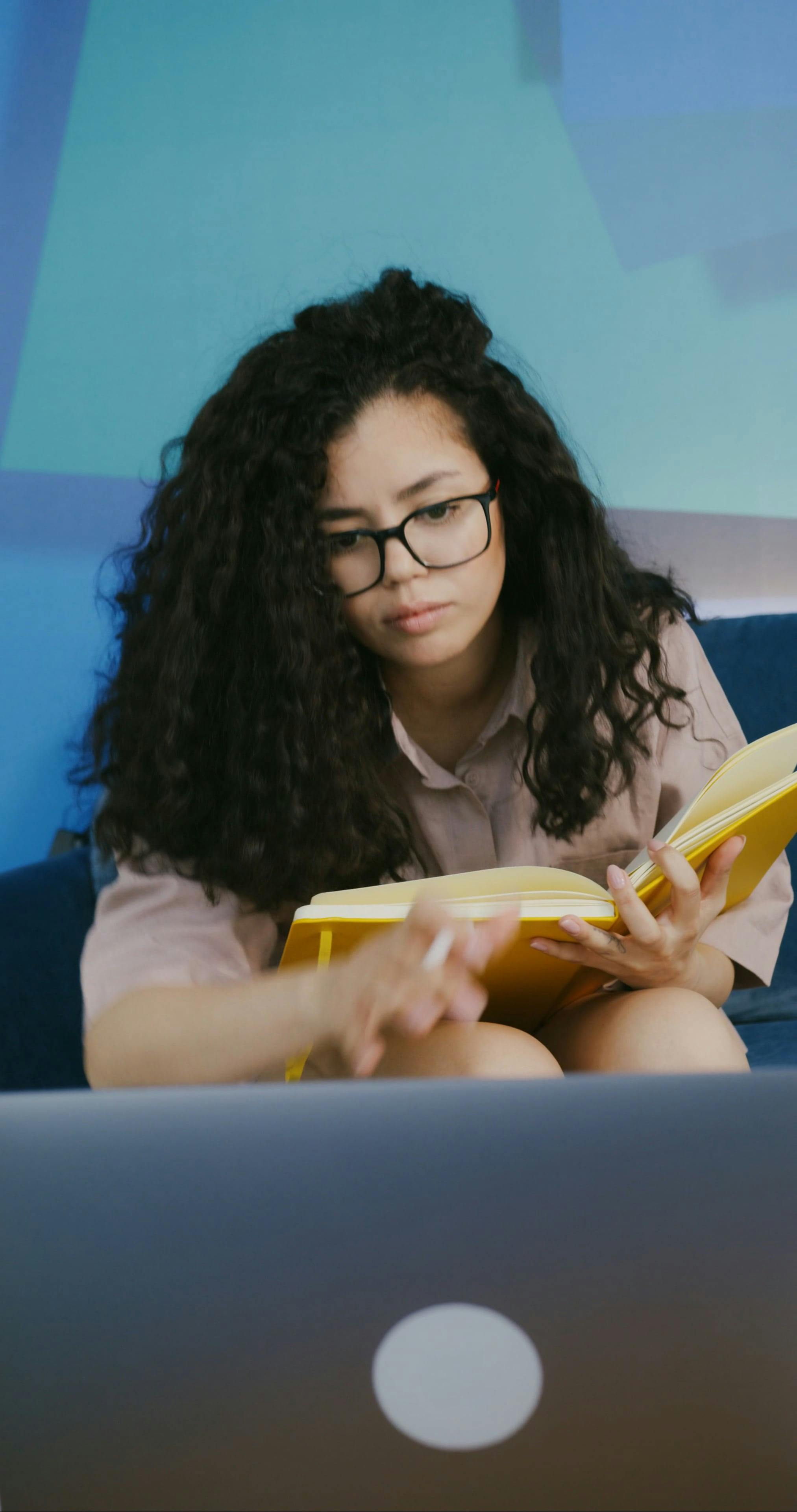 A Woman Taking Notes while Reading Information on a Laptop · Free Stock ...