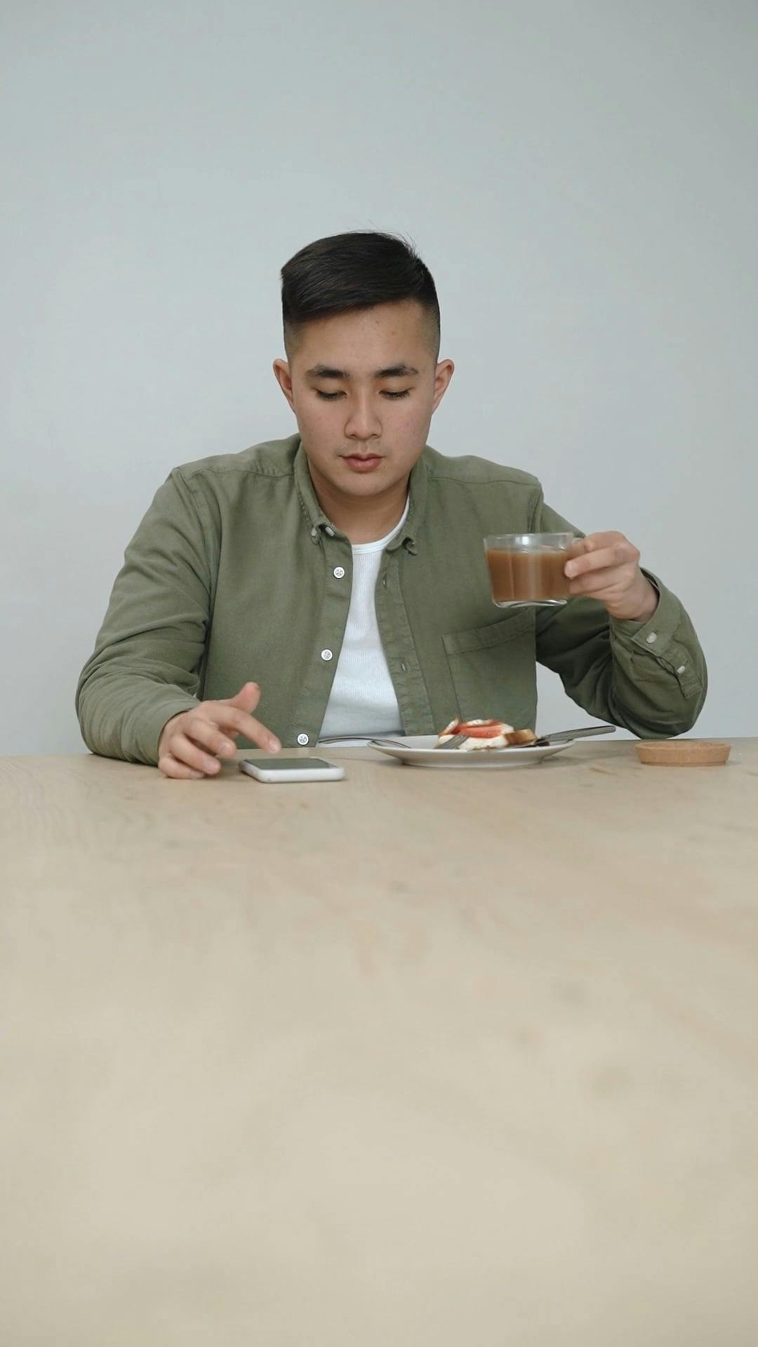 Man Eating and Drinking while using Smartphone · Free Stock Video