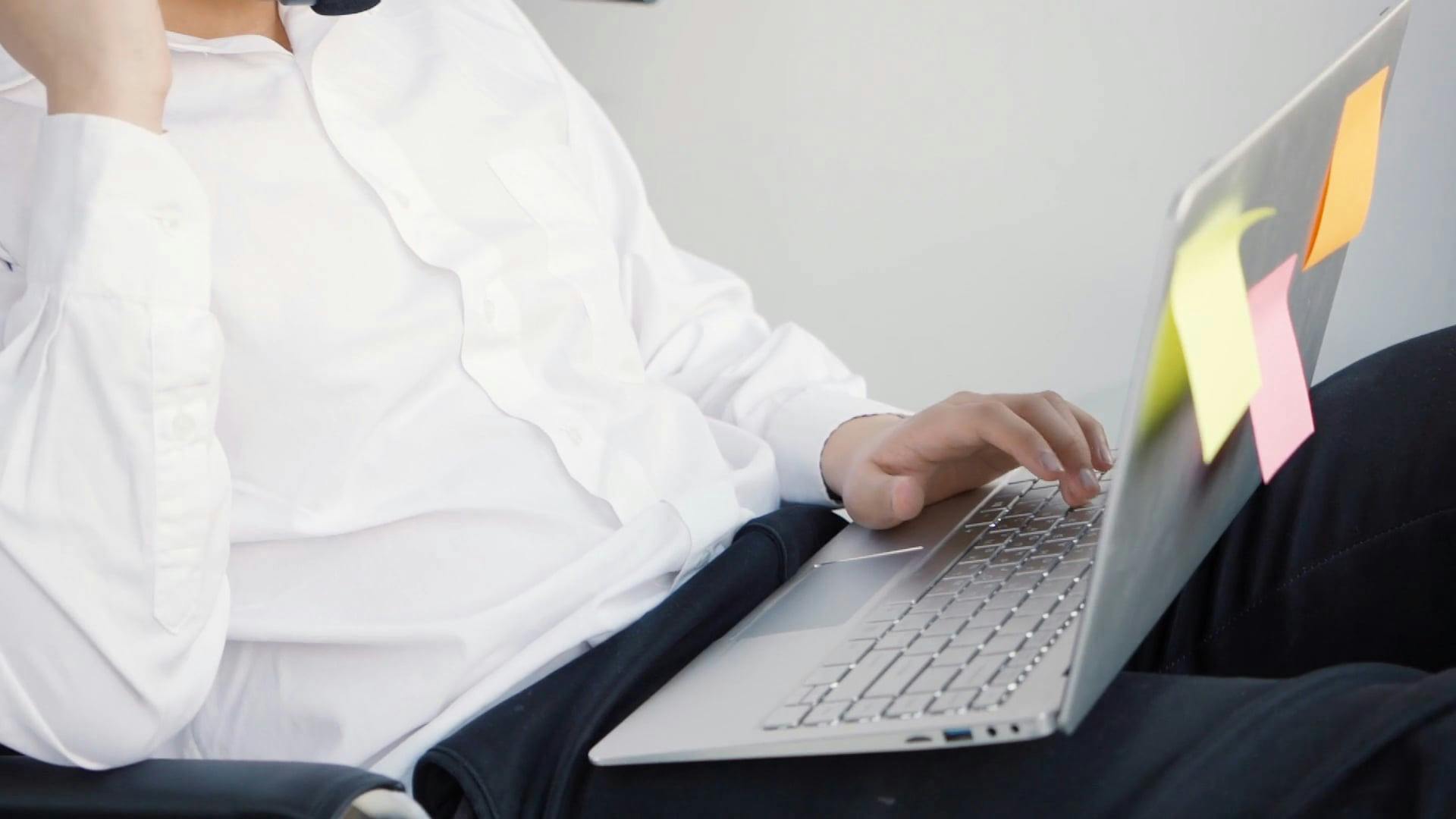 A Man Talking to a Client While Typing on His Laptop · Free Stock Video