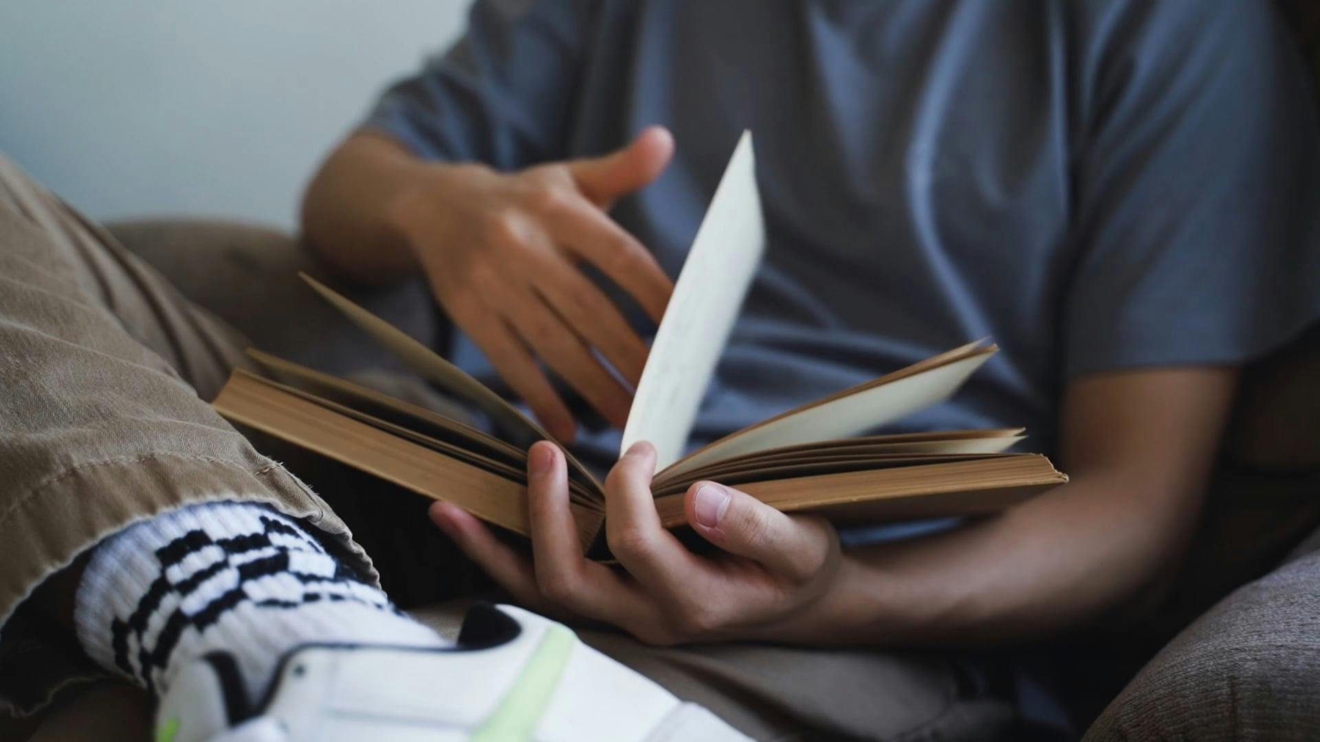 Man Flipping the Page of Book while Sitting · Free Stock Video