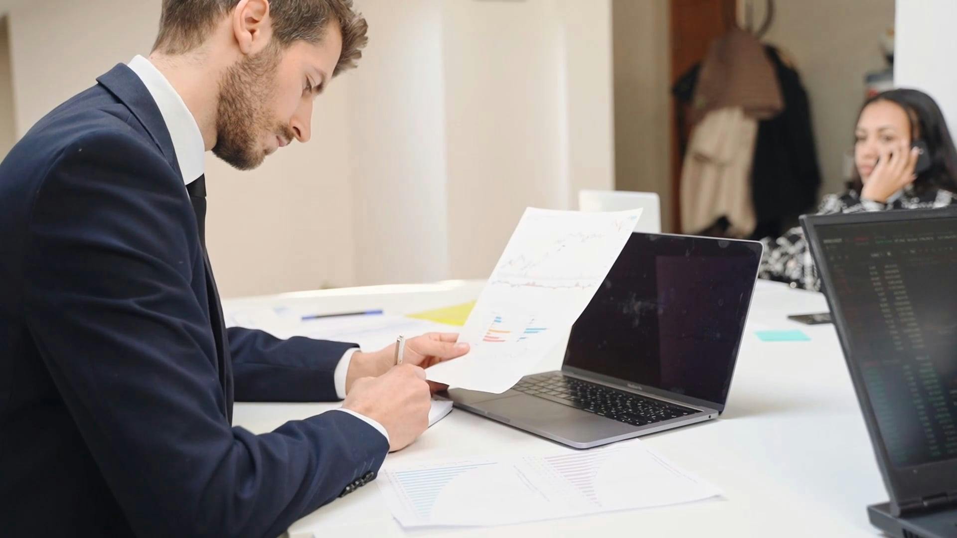 Man Holding a Paper while Taking Notes · Free Stock Video