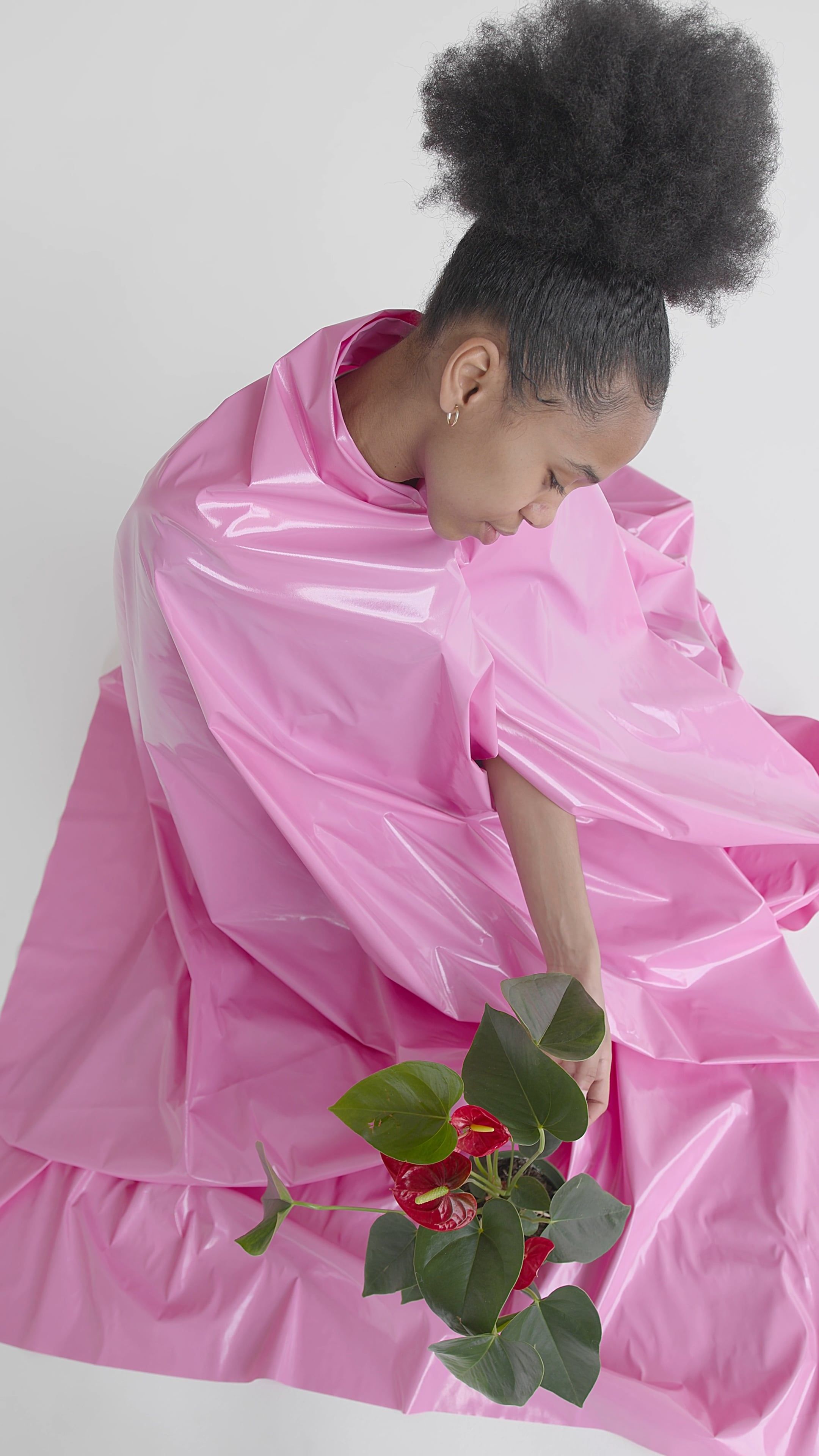 Woman Covered with Pink Plastic Touching a Plant · Free Stock Video