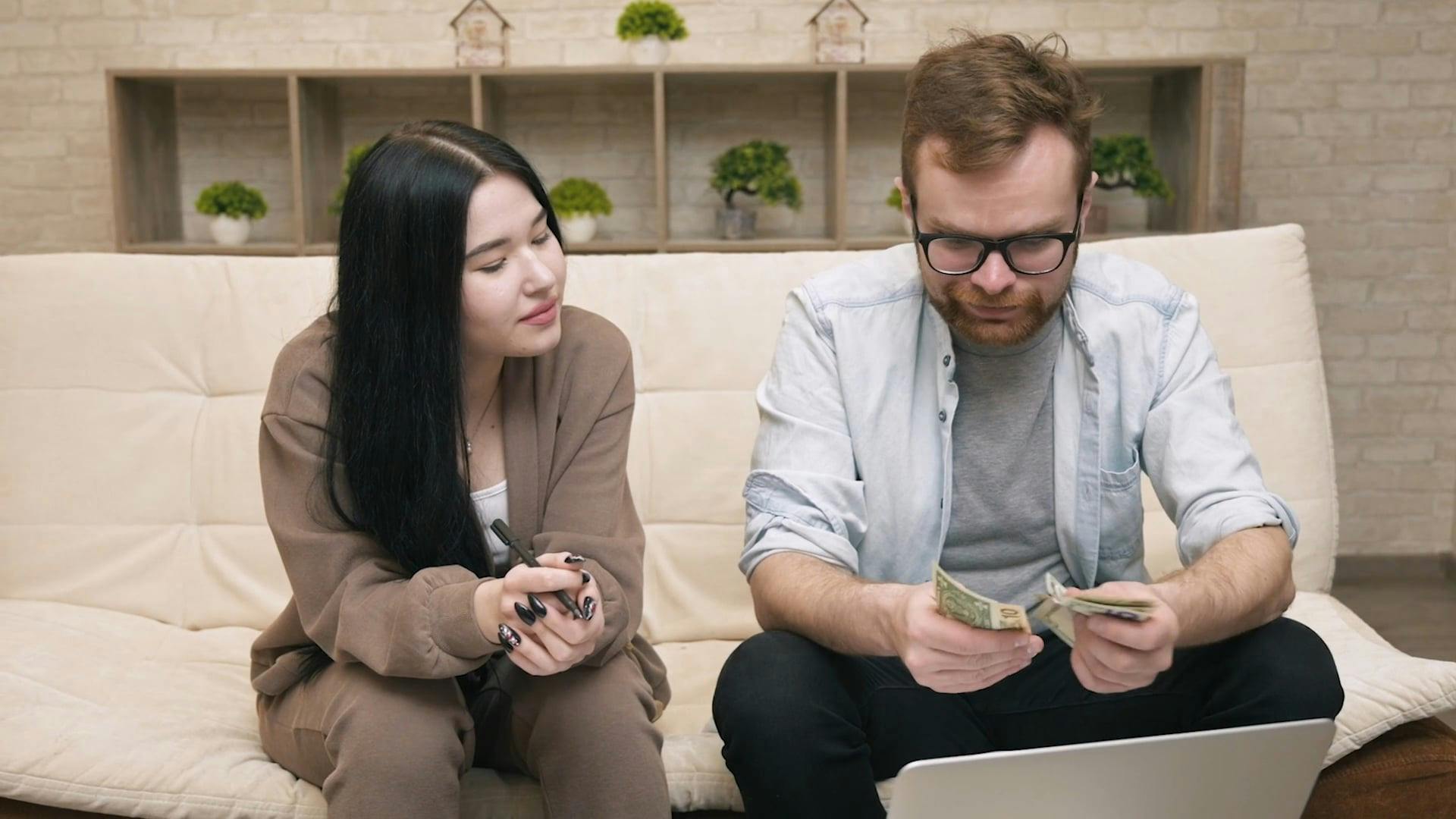 Couple Counting Money in Front of Computer · Free Stock Video