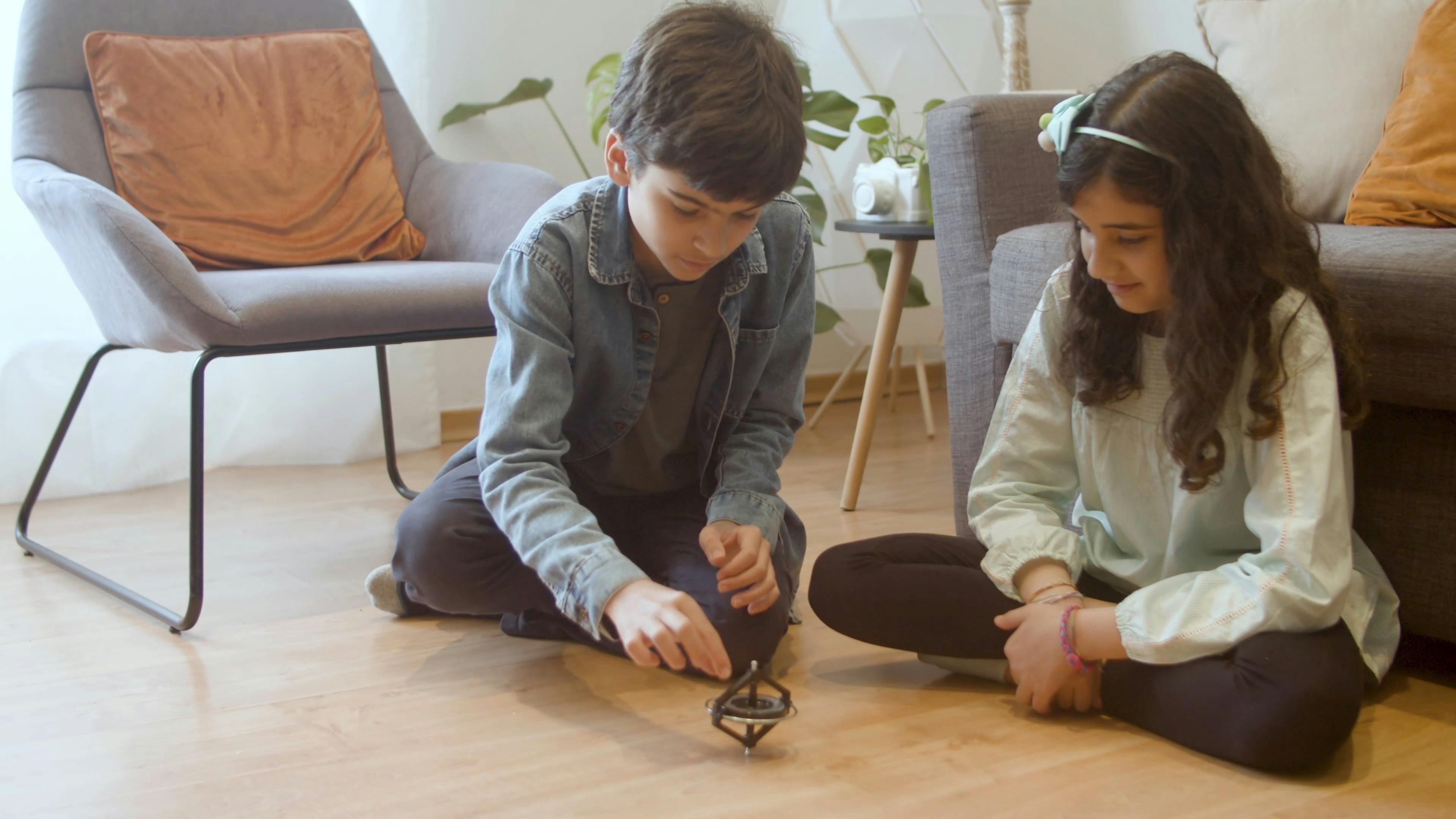 Kids Playing with a Gyroscope on the Floor · Free Stock Video