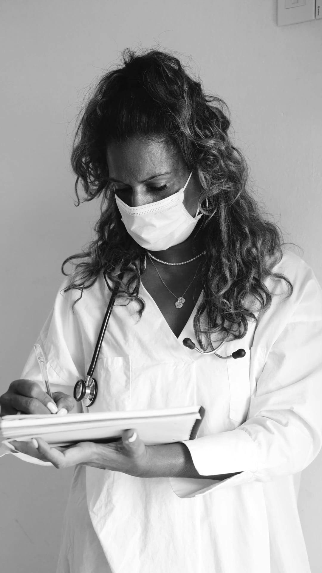 Woman Wearing Face Writing on a Notebook · Free Stock Video