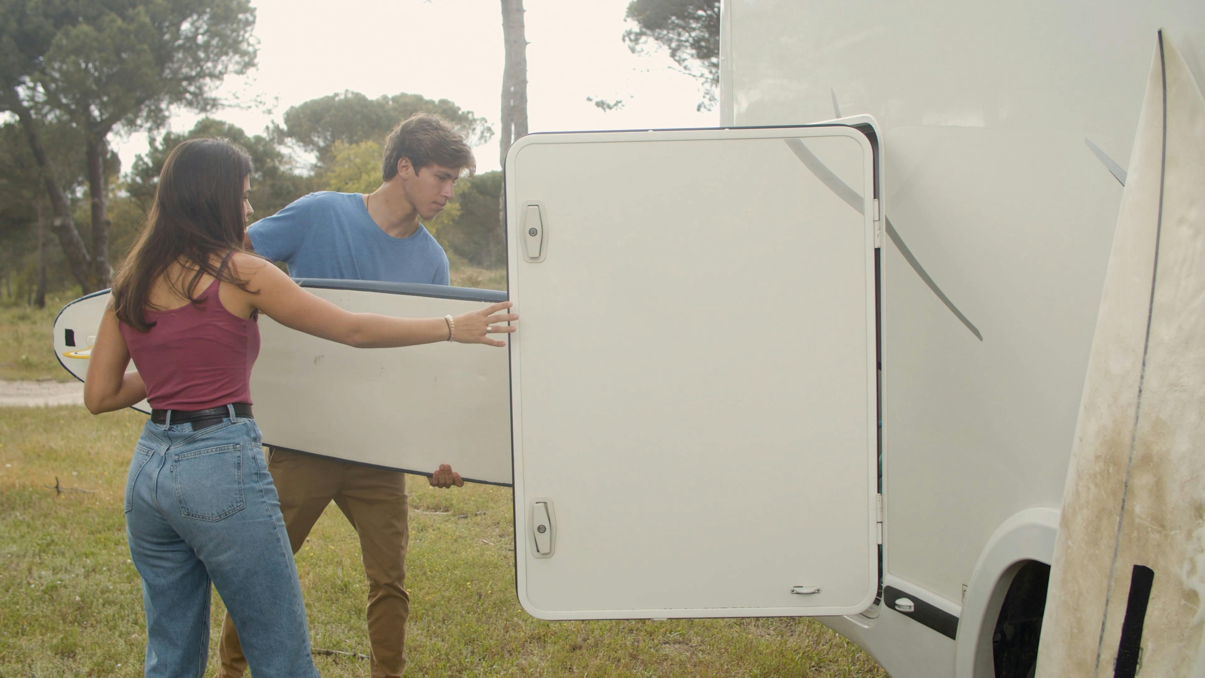 Couple Loading Their Surfboards In a Trailer · Free Stock Video