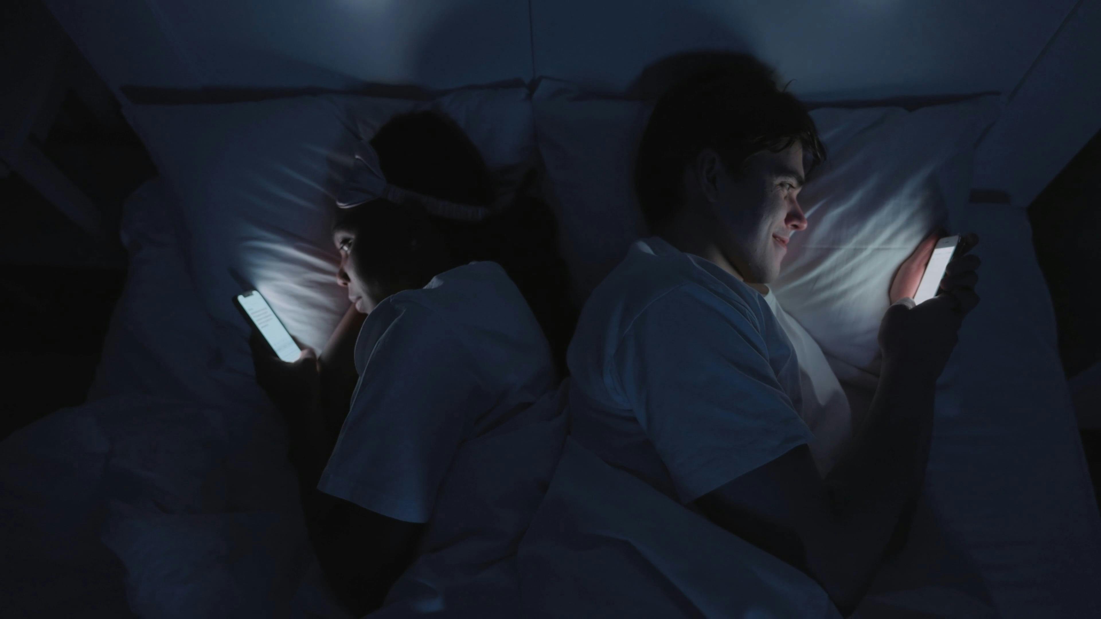 Couple Using Smartphone while Lying Down on the Bed · Free Stock Video