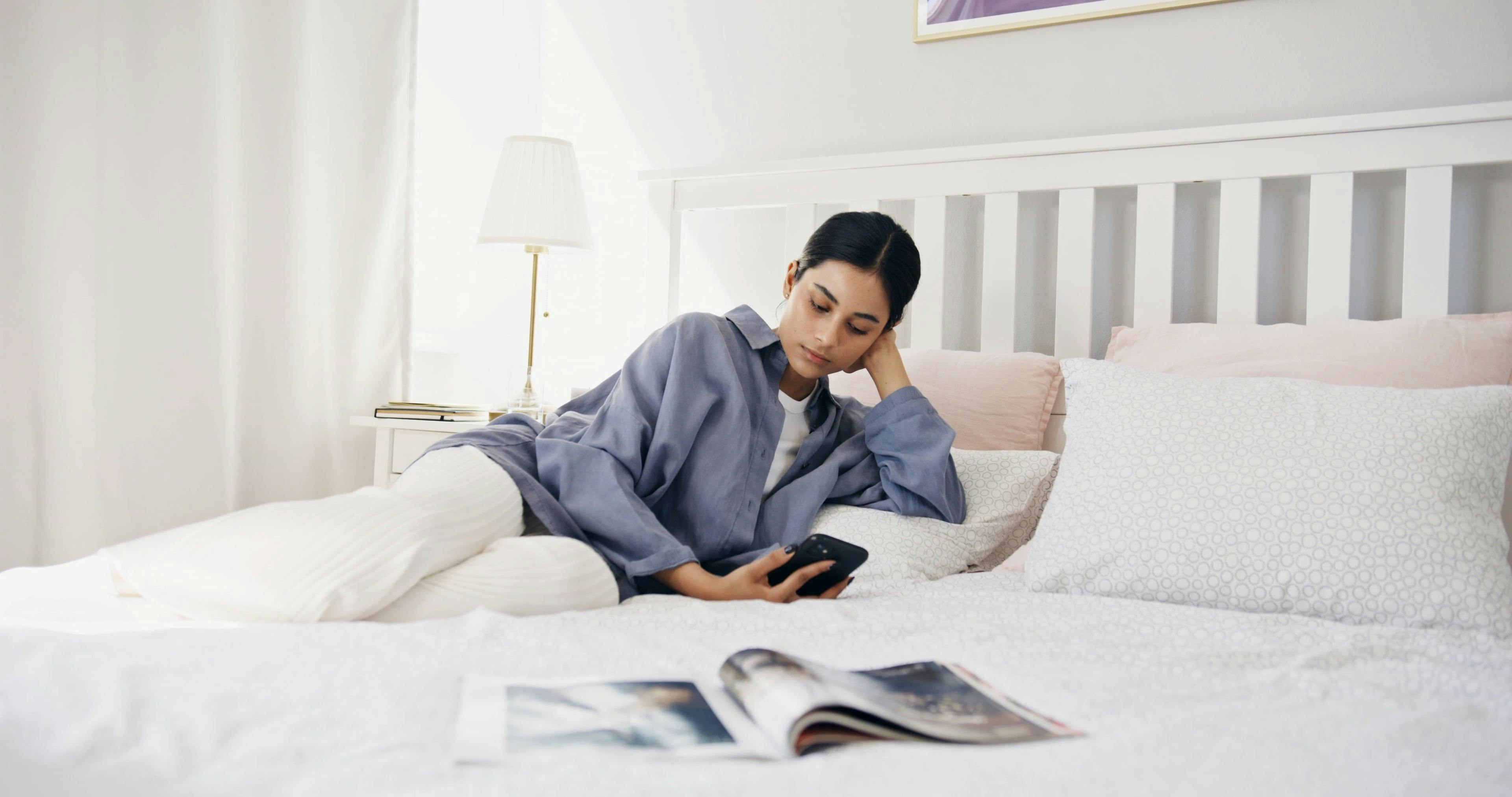 A Woman Using Her Cellphone While Lying Down On Bed · Free Stock Video