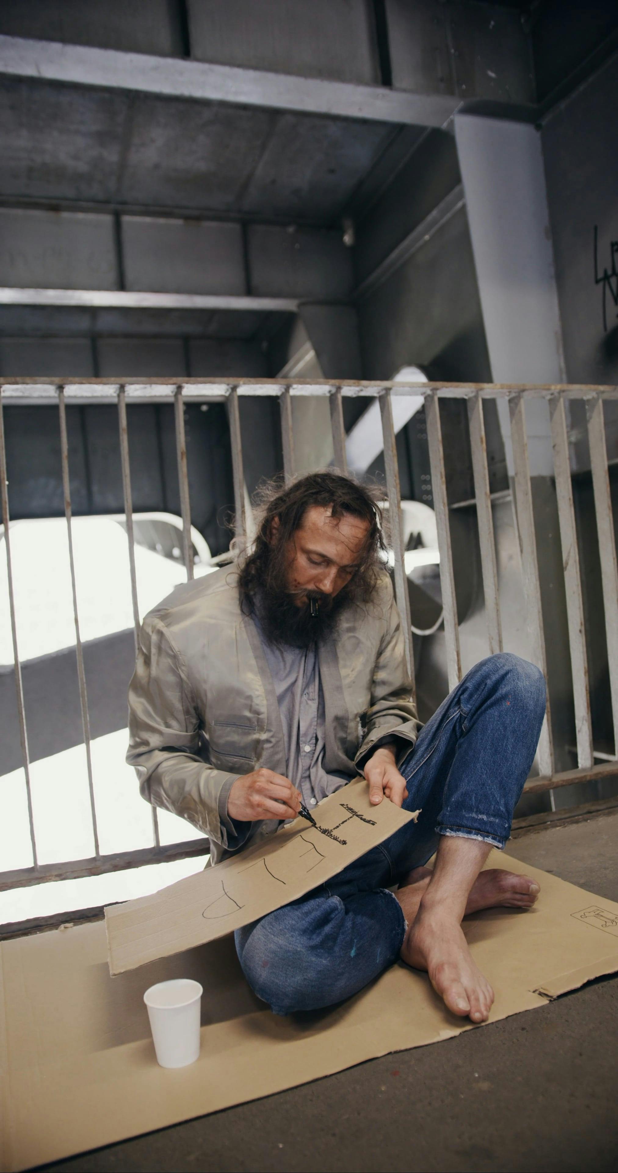 A Homeless Man Writing on a Paperboard · Free Stock Video