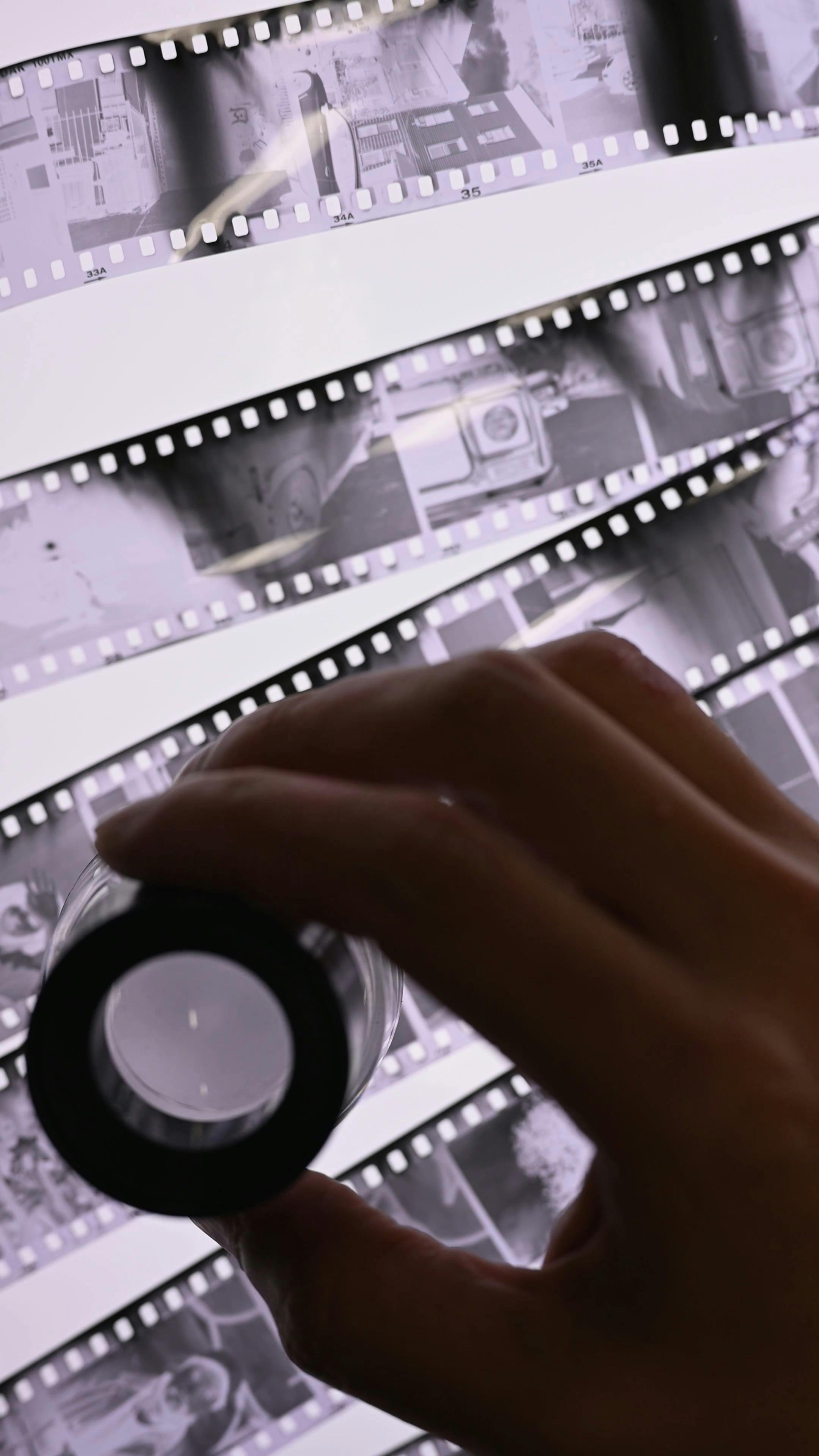 Close up of a Person using a Focus Finder on Film Strips · Free Stock Video