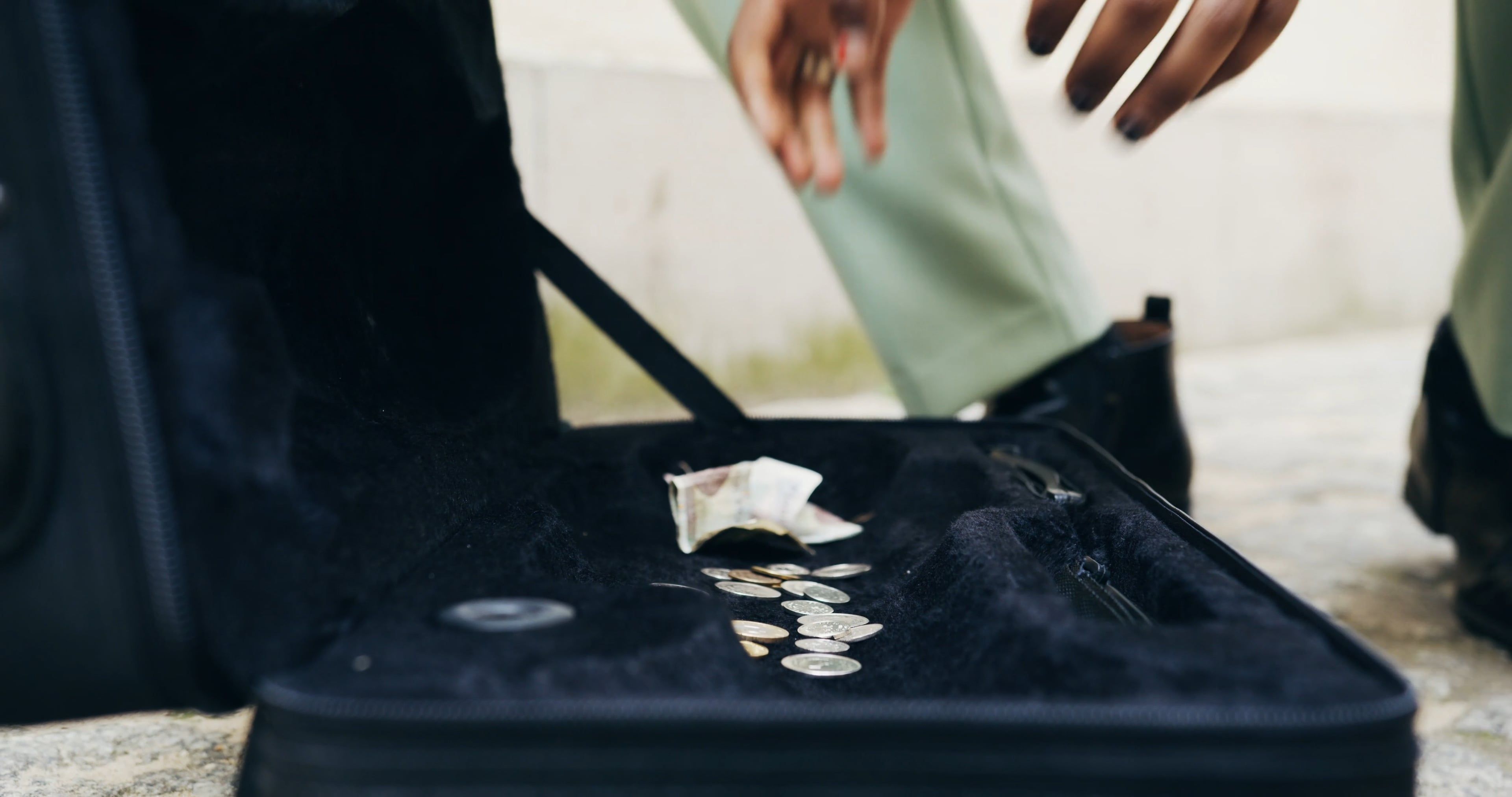 Person Picking Paper Bills and Coins on a Black Case · Free Stock Video