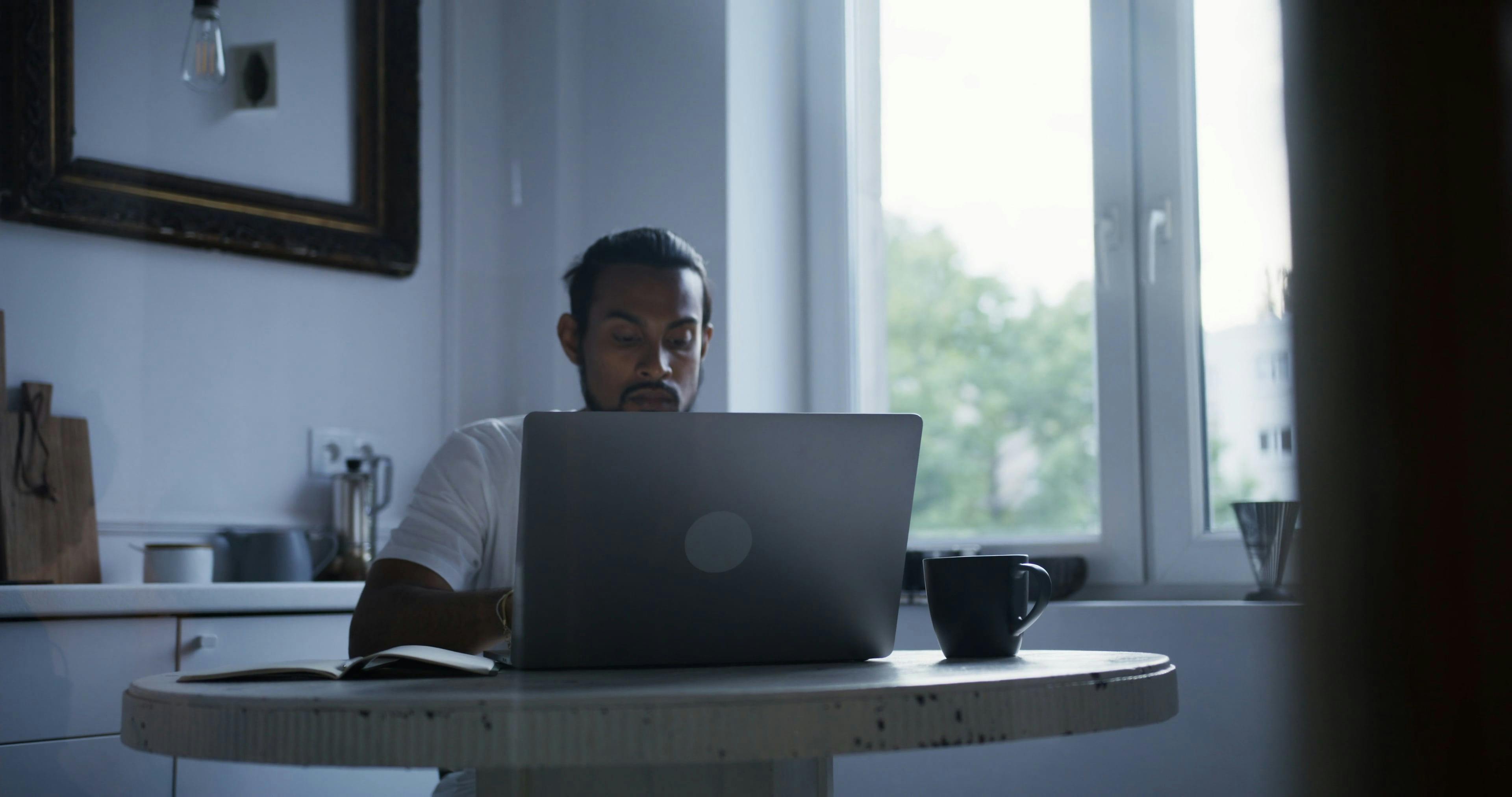 A Man Using His Laptop and Taking Notes · Free Stock Video