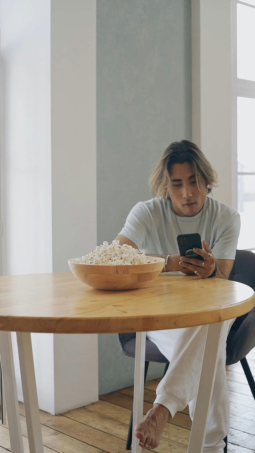 Man Eating Popcorn while Browsing on his Phone Free Stock Video Footage ...