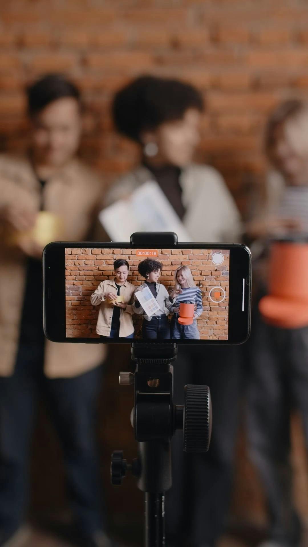 A Cellphone on a Stand Recording a Video of People · Free Stock Video