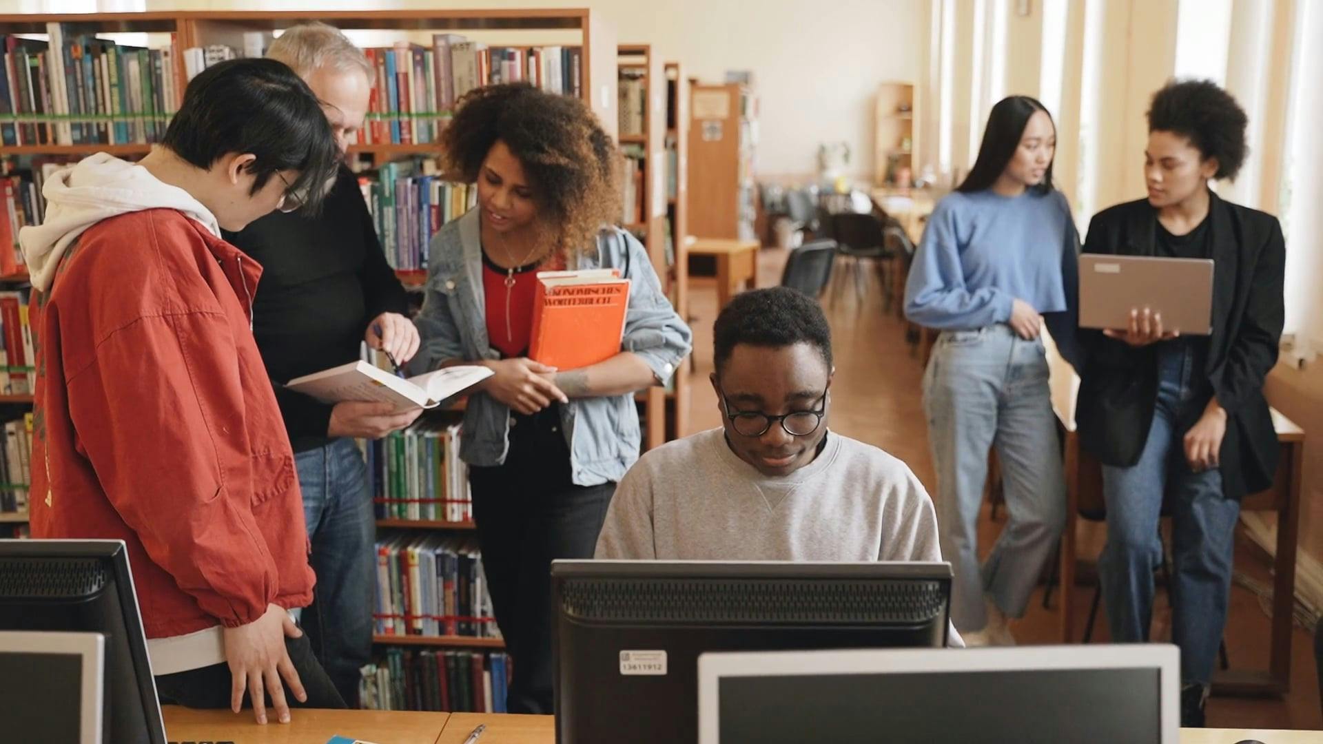 Students Doing Research with their Teacher in the Library Free Stock ...