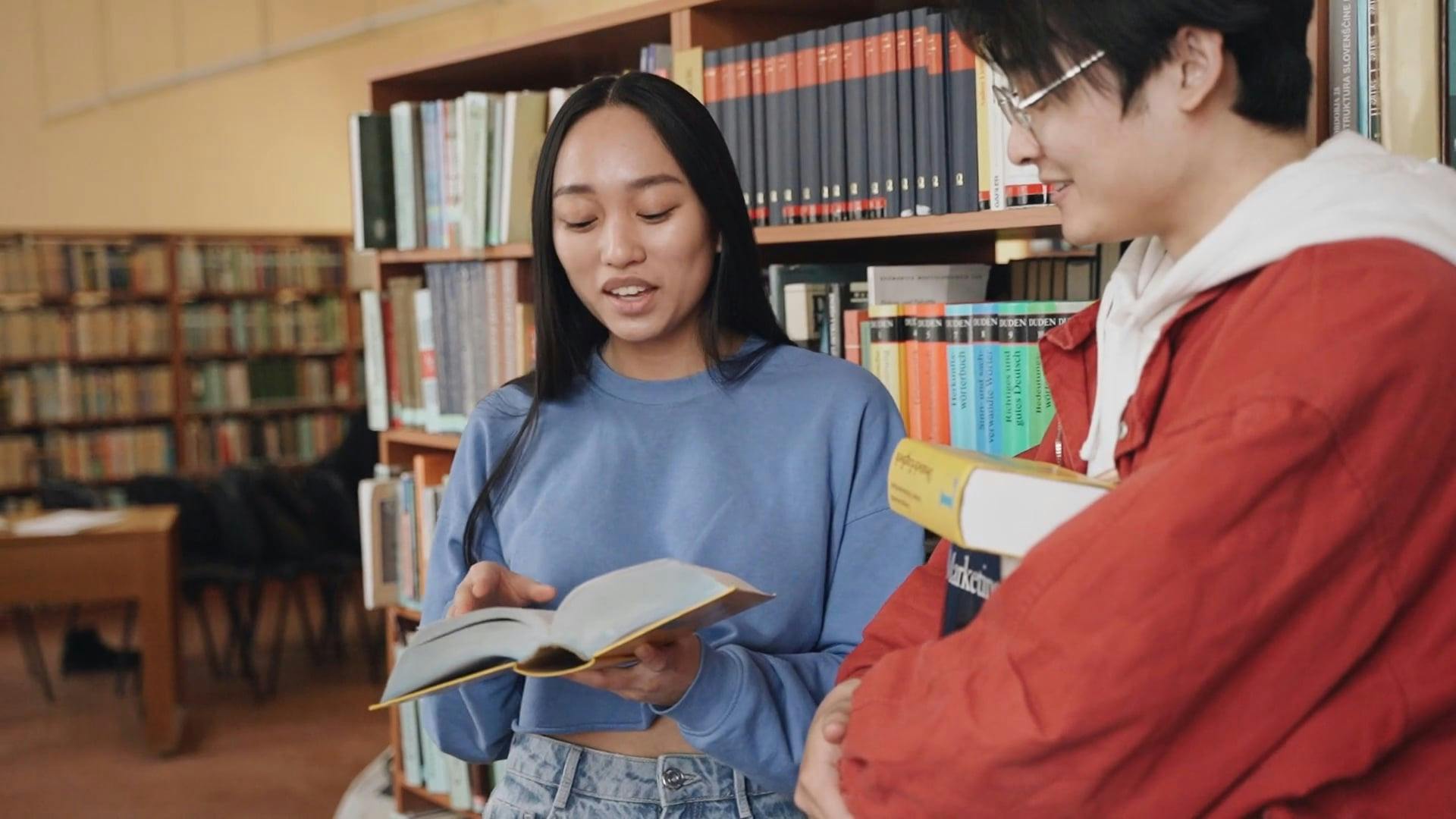 People Standing and Reading Book in the Library · Free Stock Video