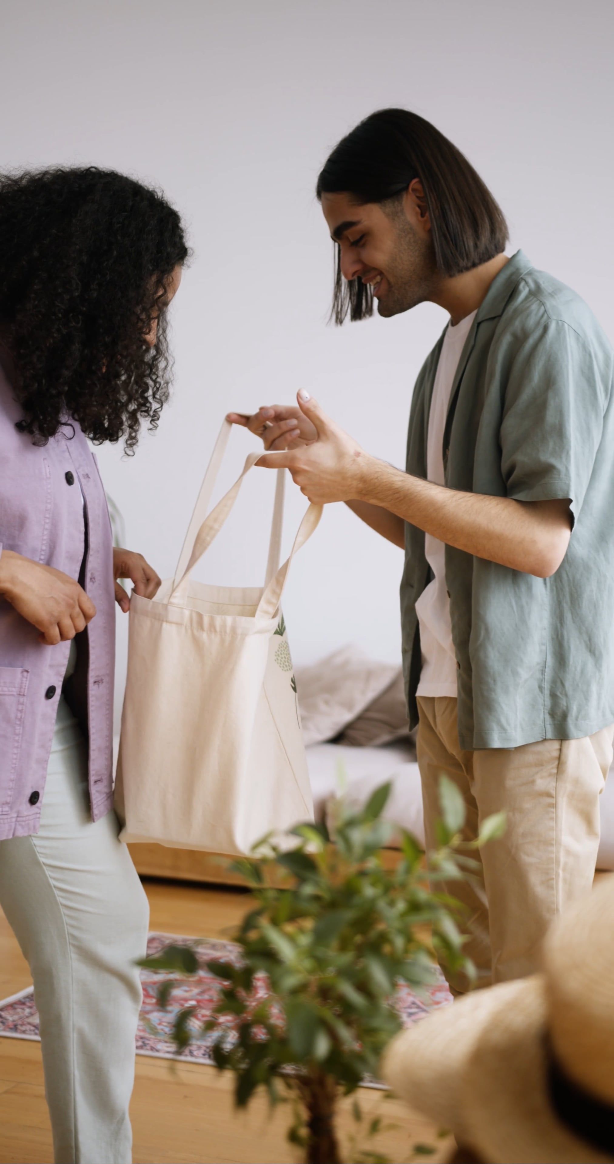 A Man Holding a Bag While a Woman is Getting Some Books from it · Free ...