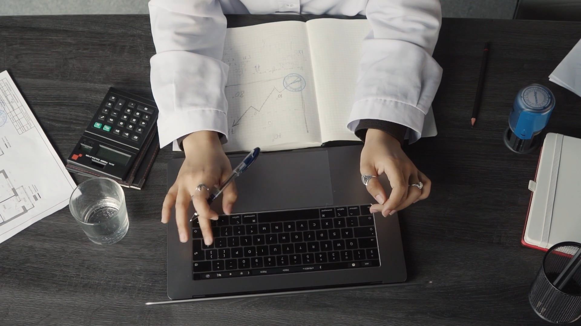 A Person Typing on a Laptop and Working on Paperwork · Free Stock Video