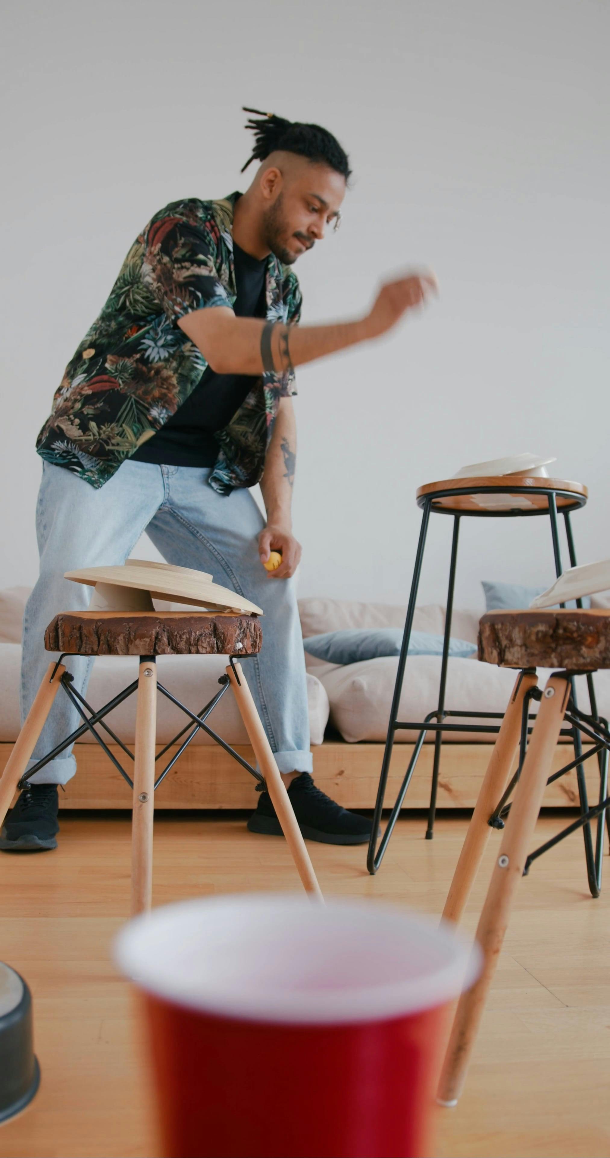 Blogger Bouncing Ping Pong Balls on Plates Placed on Wooden Stools Free ...