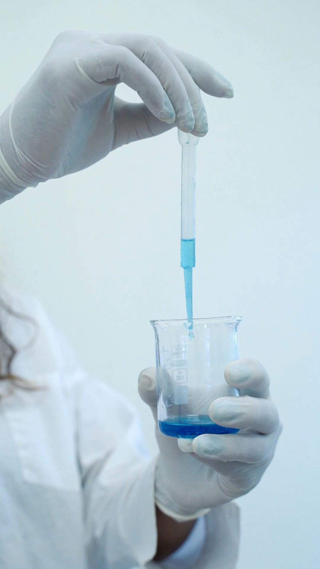 Dropping Colored Liquid Using a Dropper into a Beaker · Free Stock Video