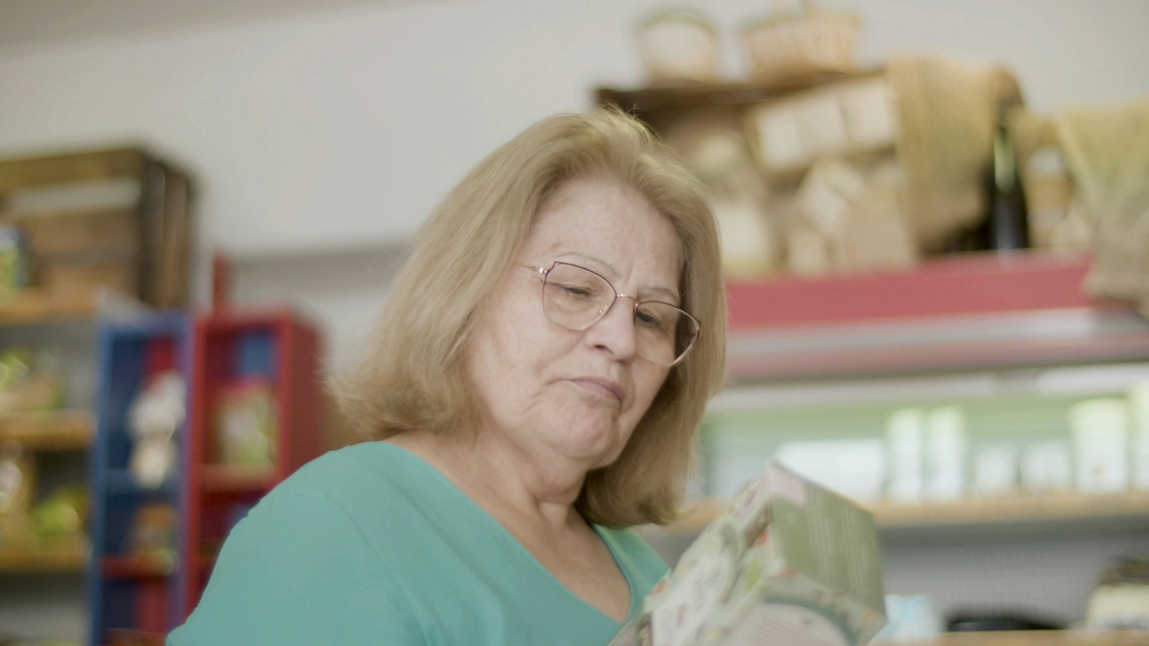 An Elderly Woman Looking at an Item in a Shop · Free Stock Video