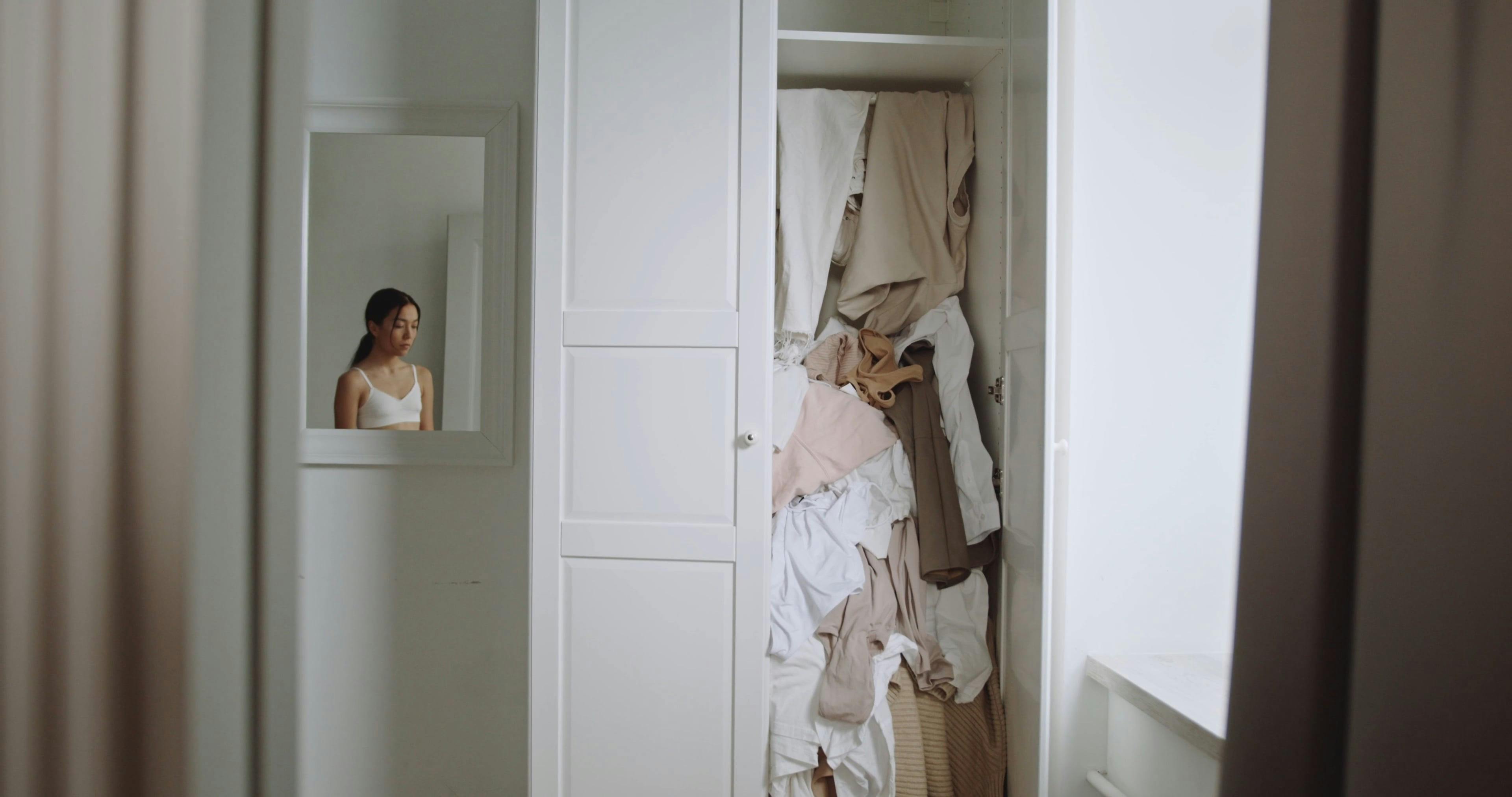 Woman Closing a Wardrobe Full of Clothes · Free Stock Video