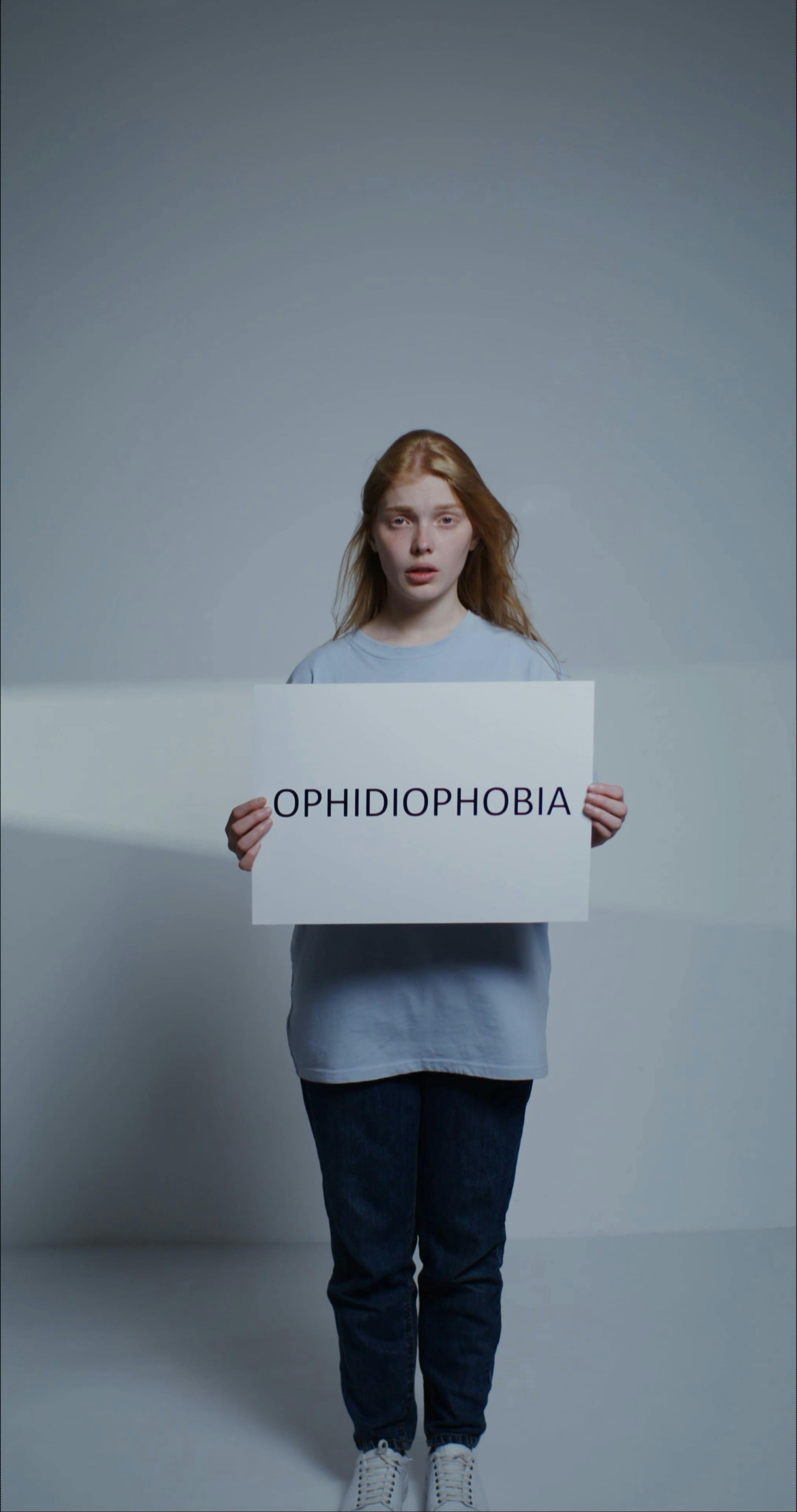 Young Woman Holding A Placard With Ophidiophobia Text Free Stock Video ...
