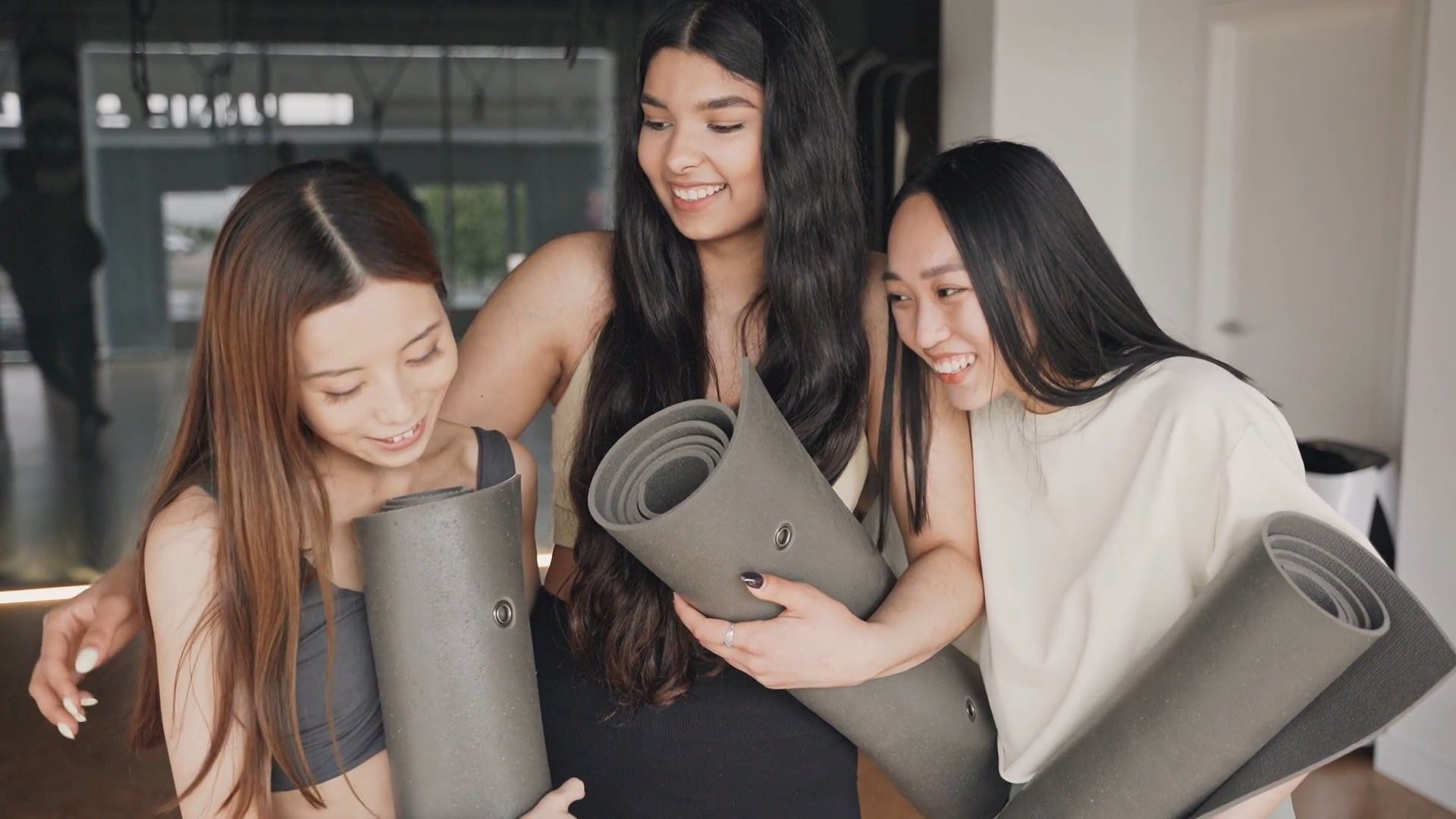 Women Hugging while Holding Yoga Mats · Free Stock Video