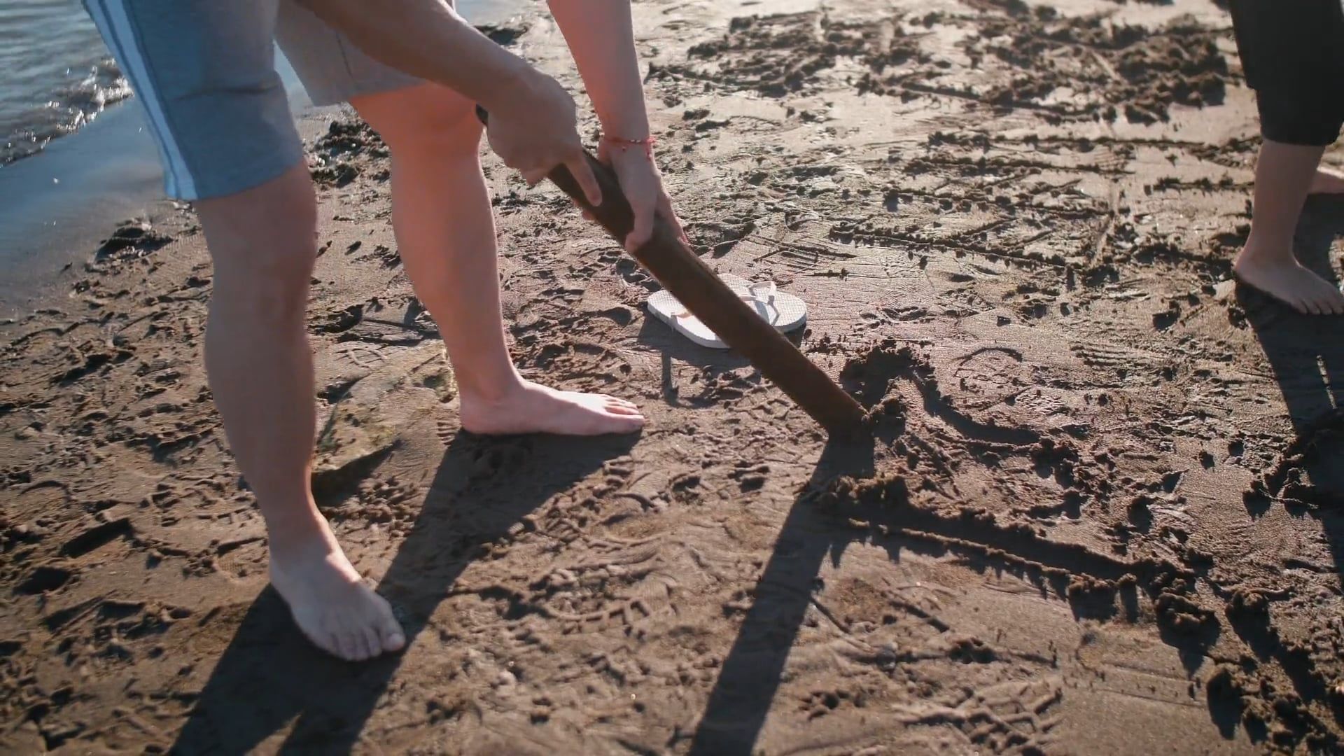 Boy Writing on Beach Sand Using a Stick · Free Stock Video