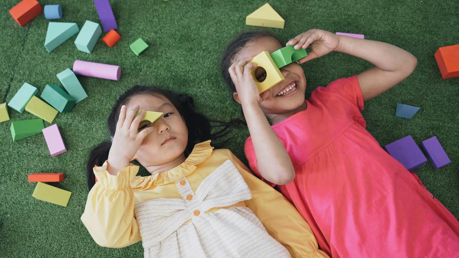 Little Girls Putting Building Blocks on Their Faces · Free Stock Video