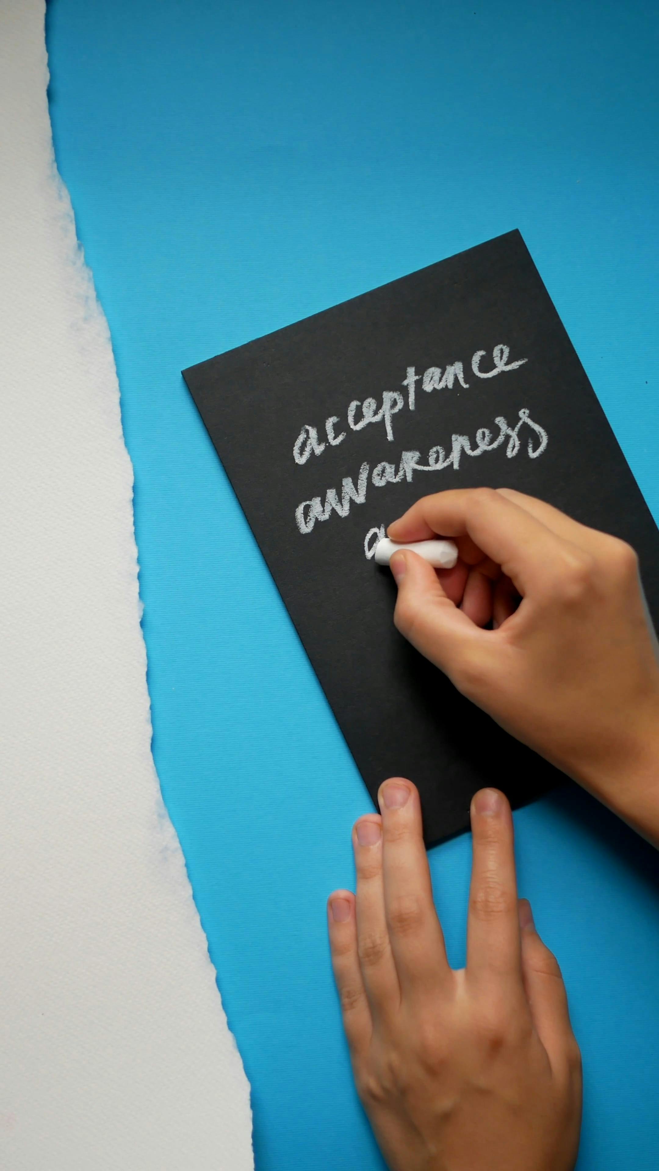 A Person Writing on a Black Paper · Free Stock Video
