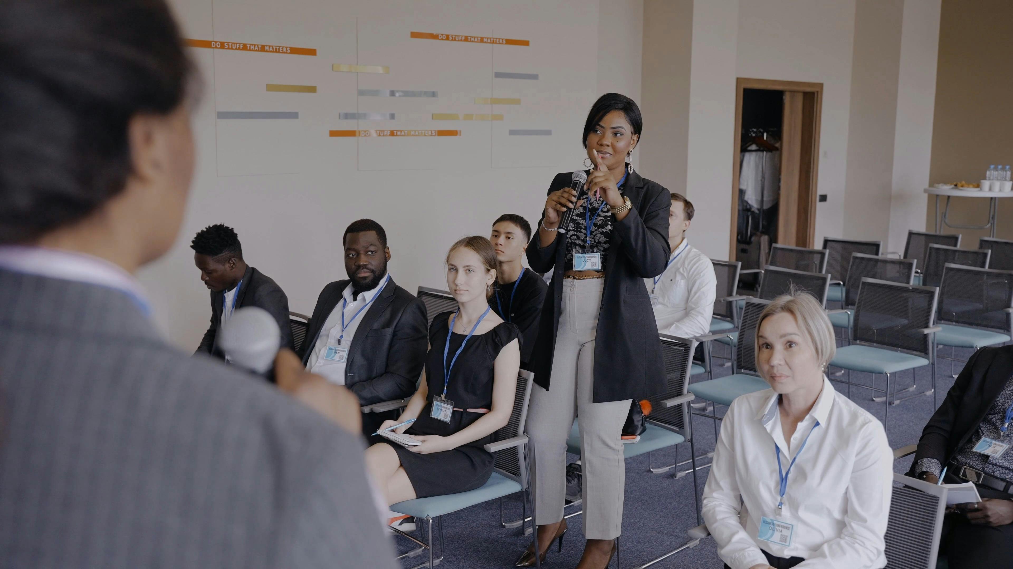 Over the Shoulder Shot of a Woman Talking to a Speaker at a Business ...