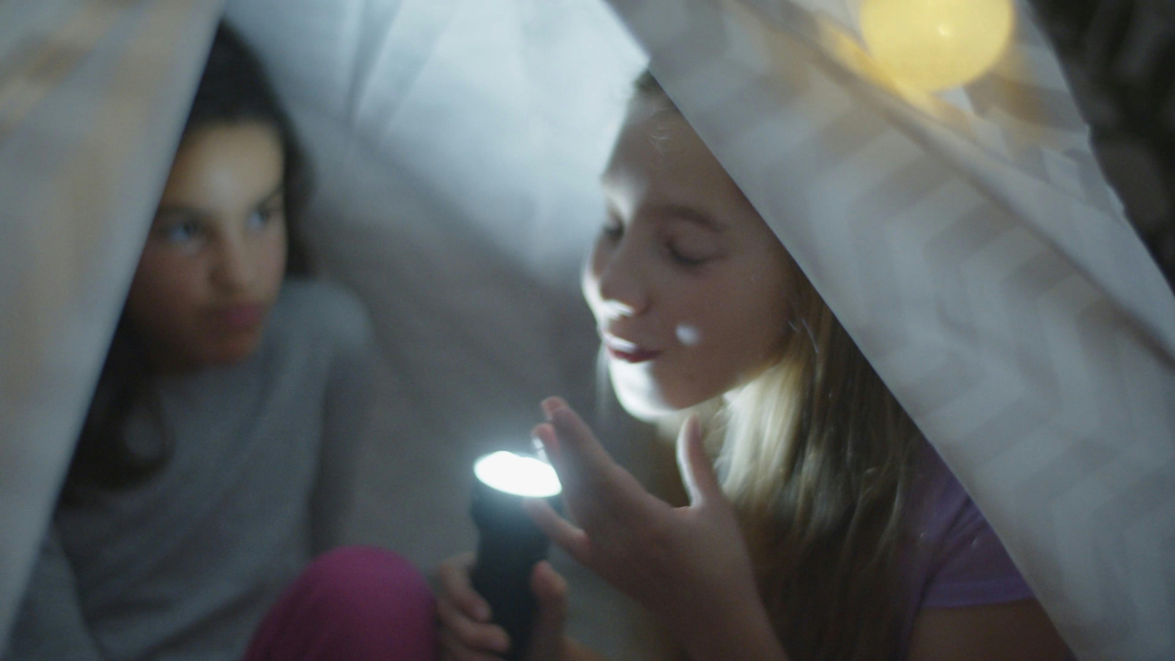 A Little Girl Telling a Story while Holding a Flashlight Free Stock ...