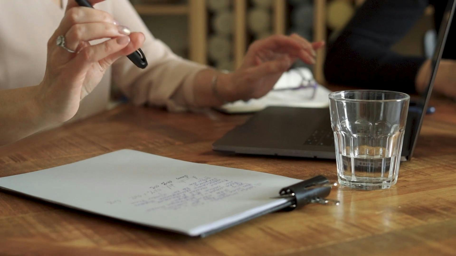 A Businessperson Taking Notes and Typing on a Laptop · Free Stock Video