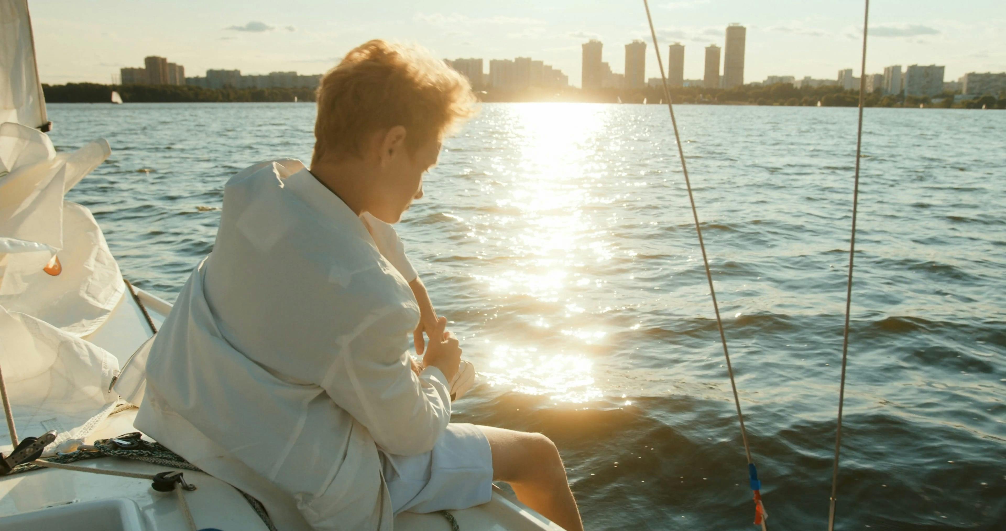 A Young Man Looking at the View While Sitting on a Boat Free Stock ...