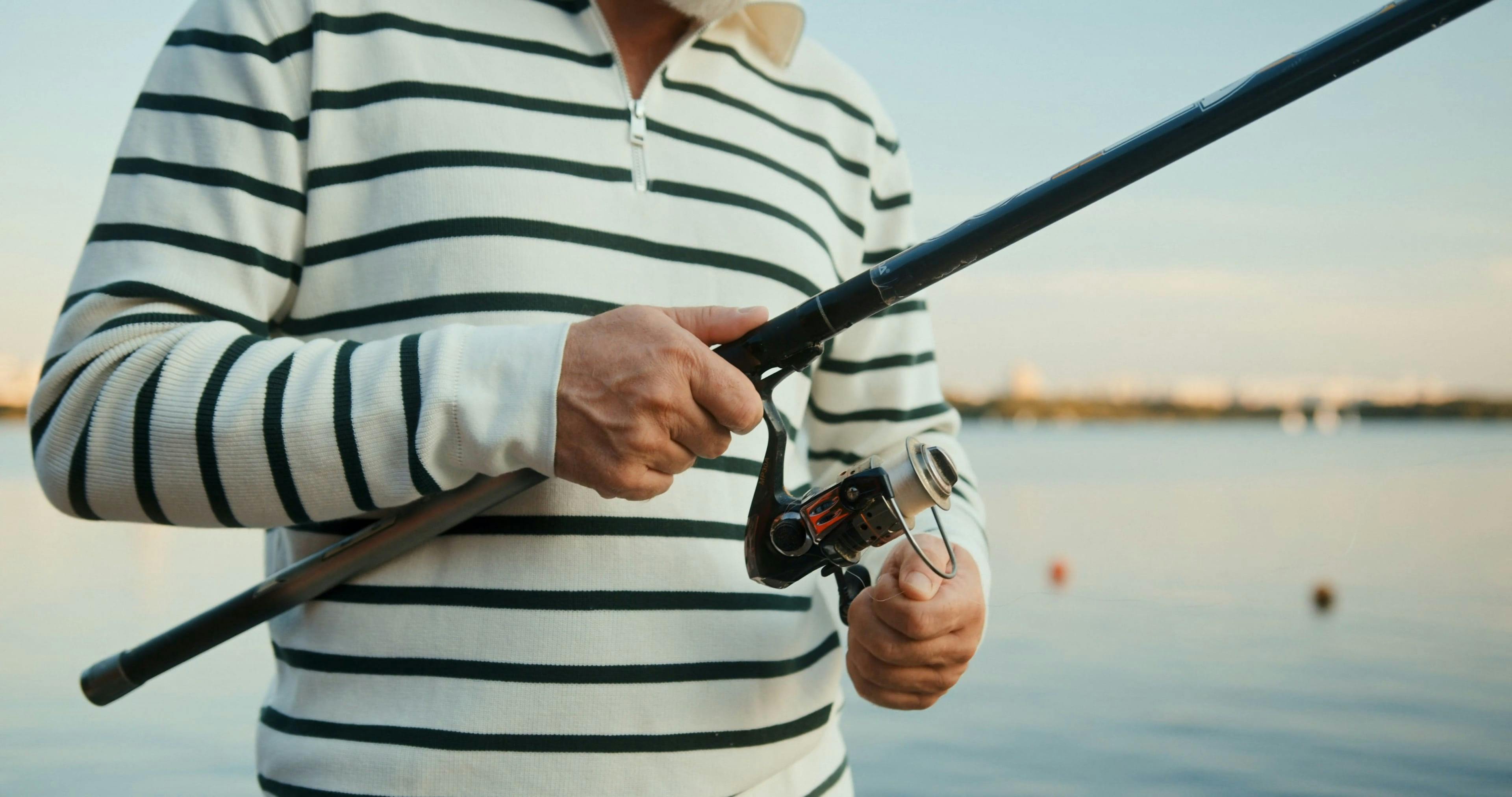 Close-up Footage of a Person Spinning the Handle of the Fishing Rod ...